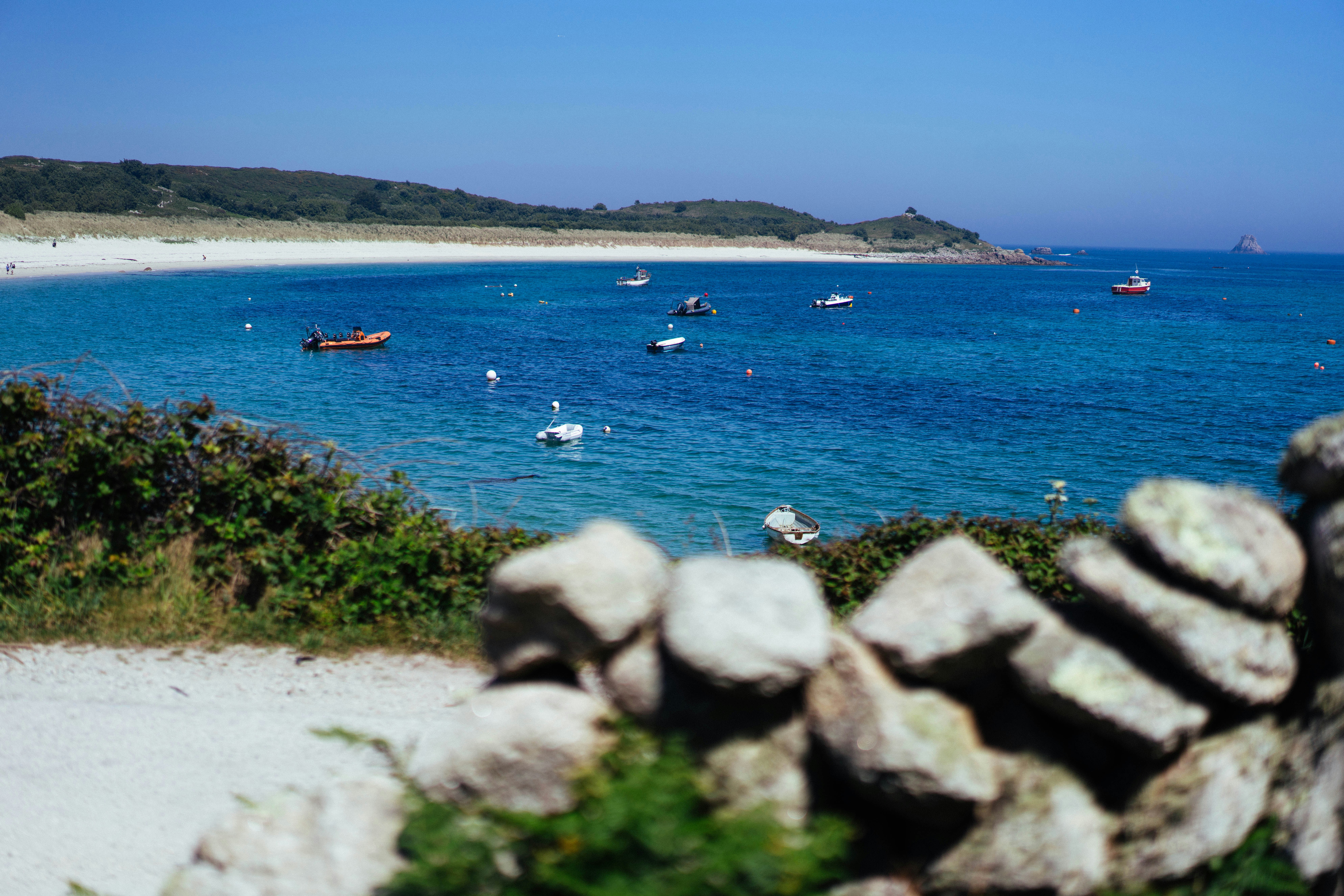 Azure Cove: Boats Resting Between the Quiet Beach and the Distant Hills