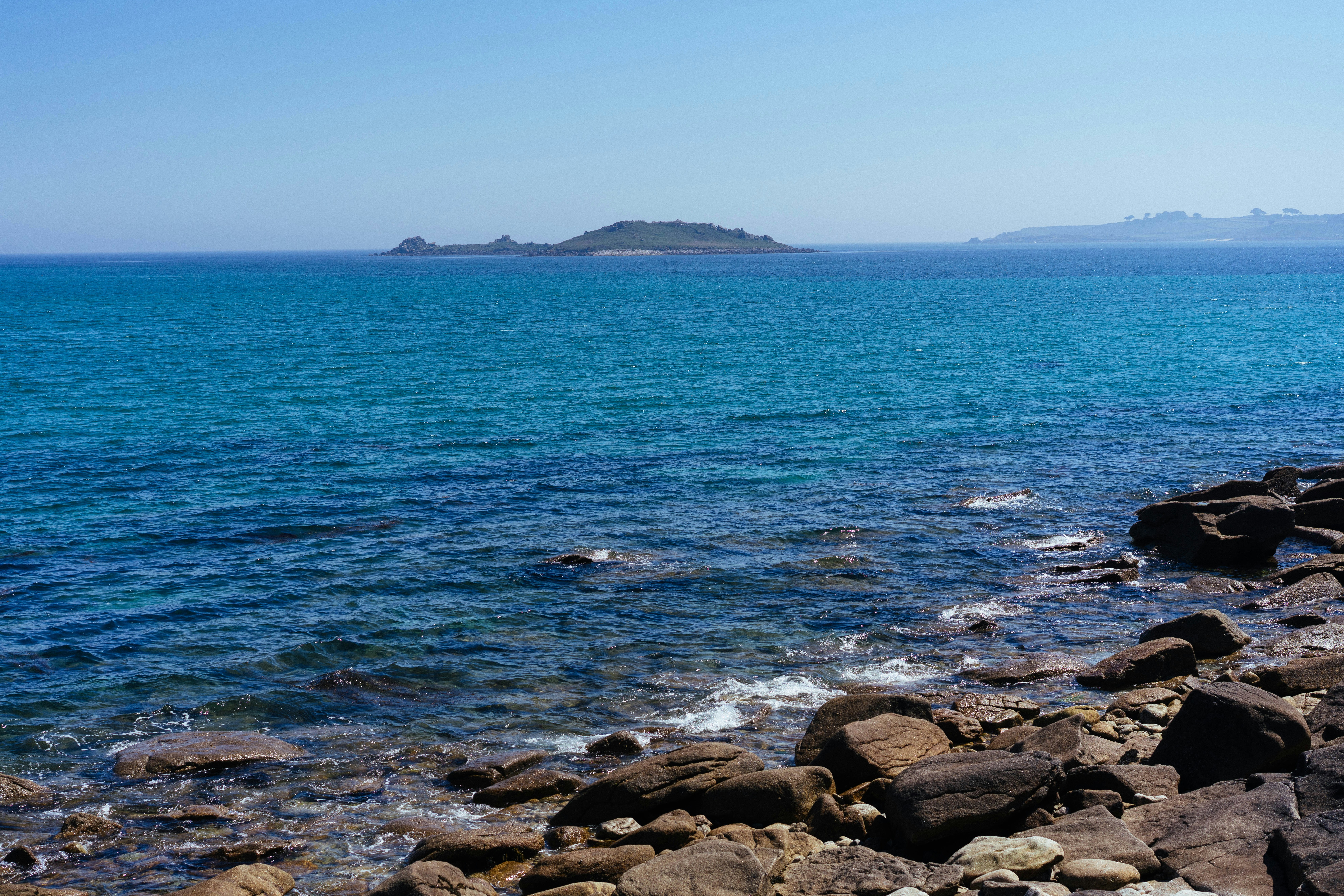 A Quiet Coastal Horizon Framed by Weathered Rocks