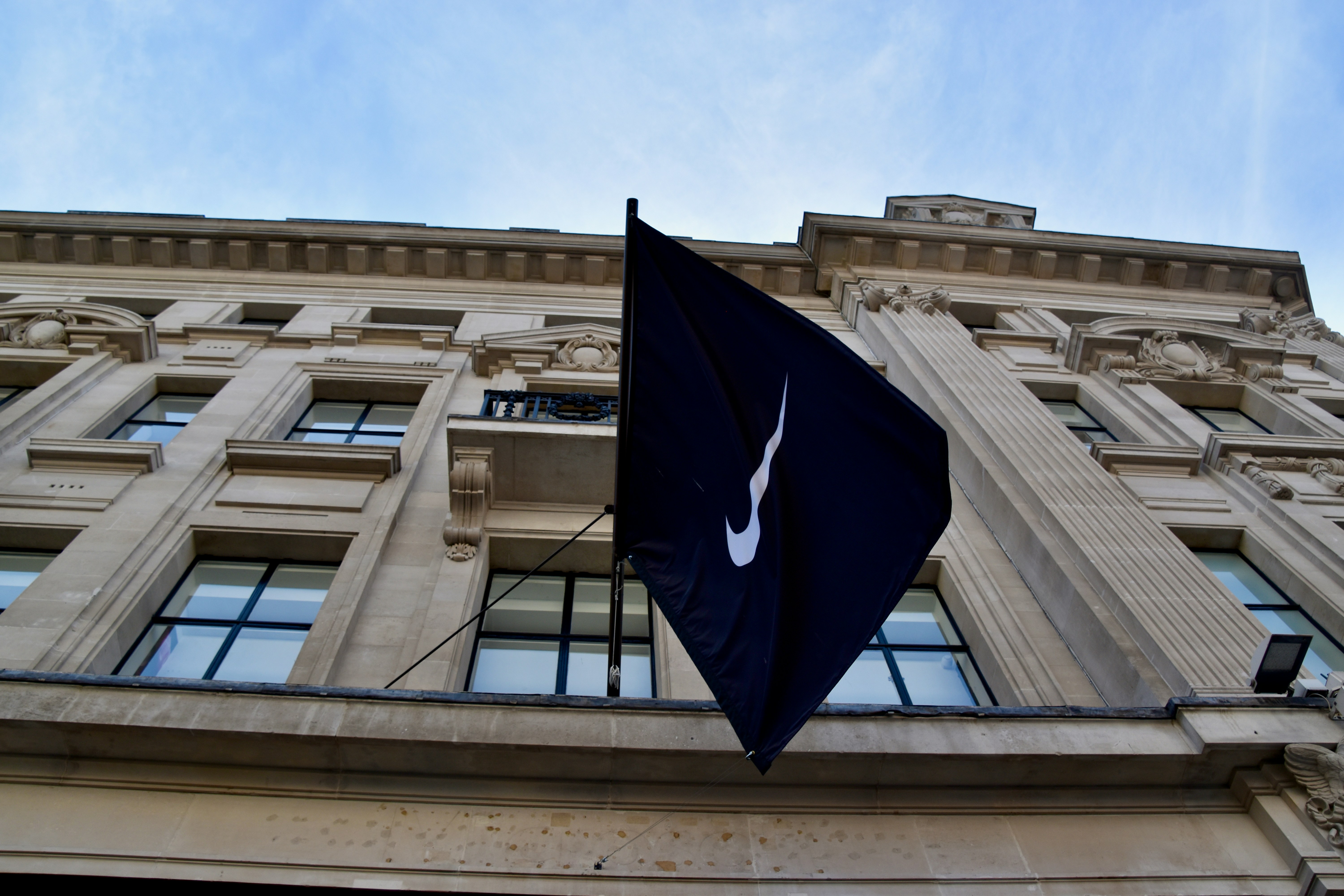Flag Against Classical Facade: A Moment of Quiet Between Stone and Sky
