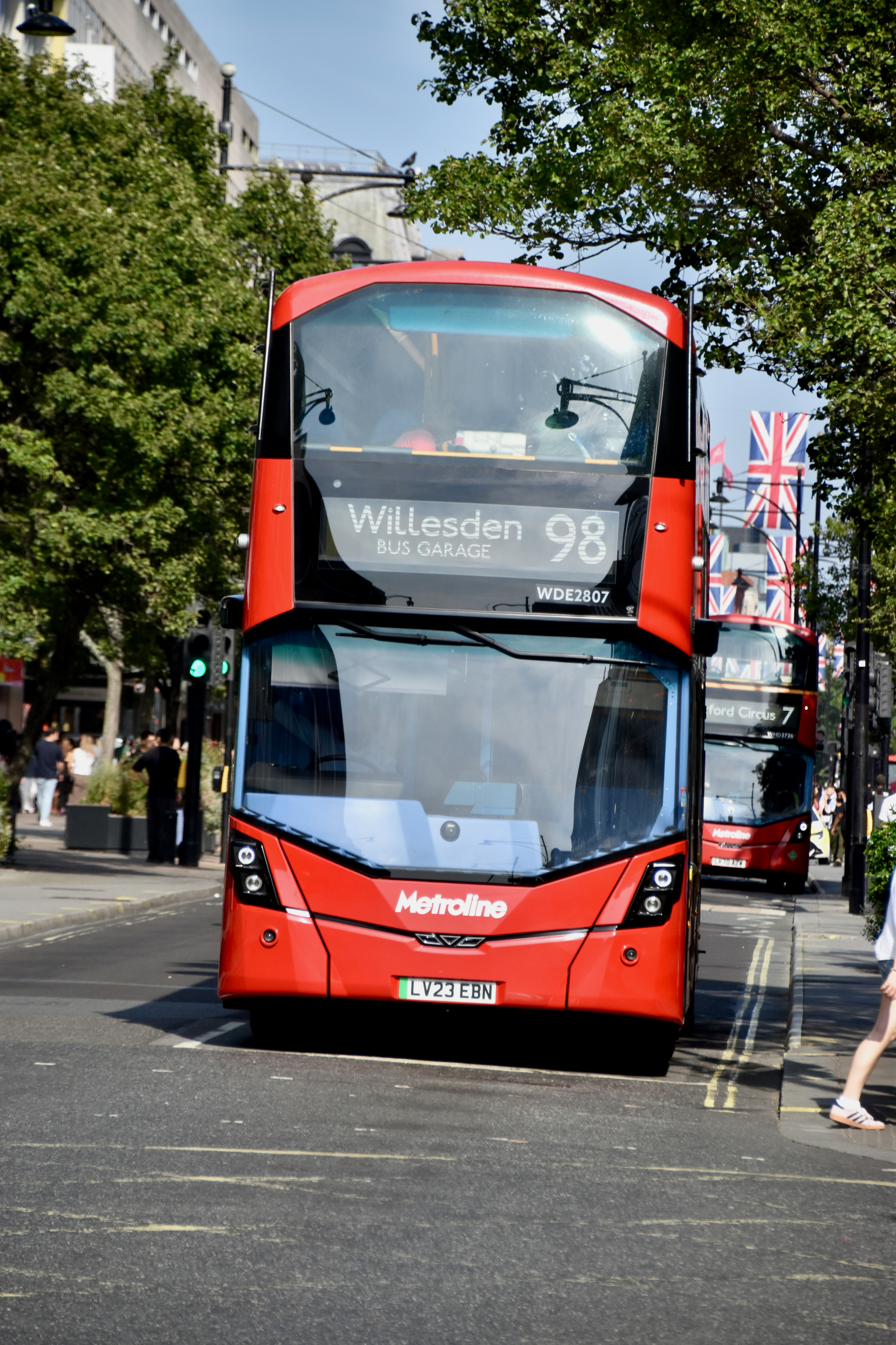 Red Duo: The City Bus Angles Forward in an Urban Parade