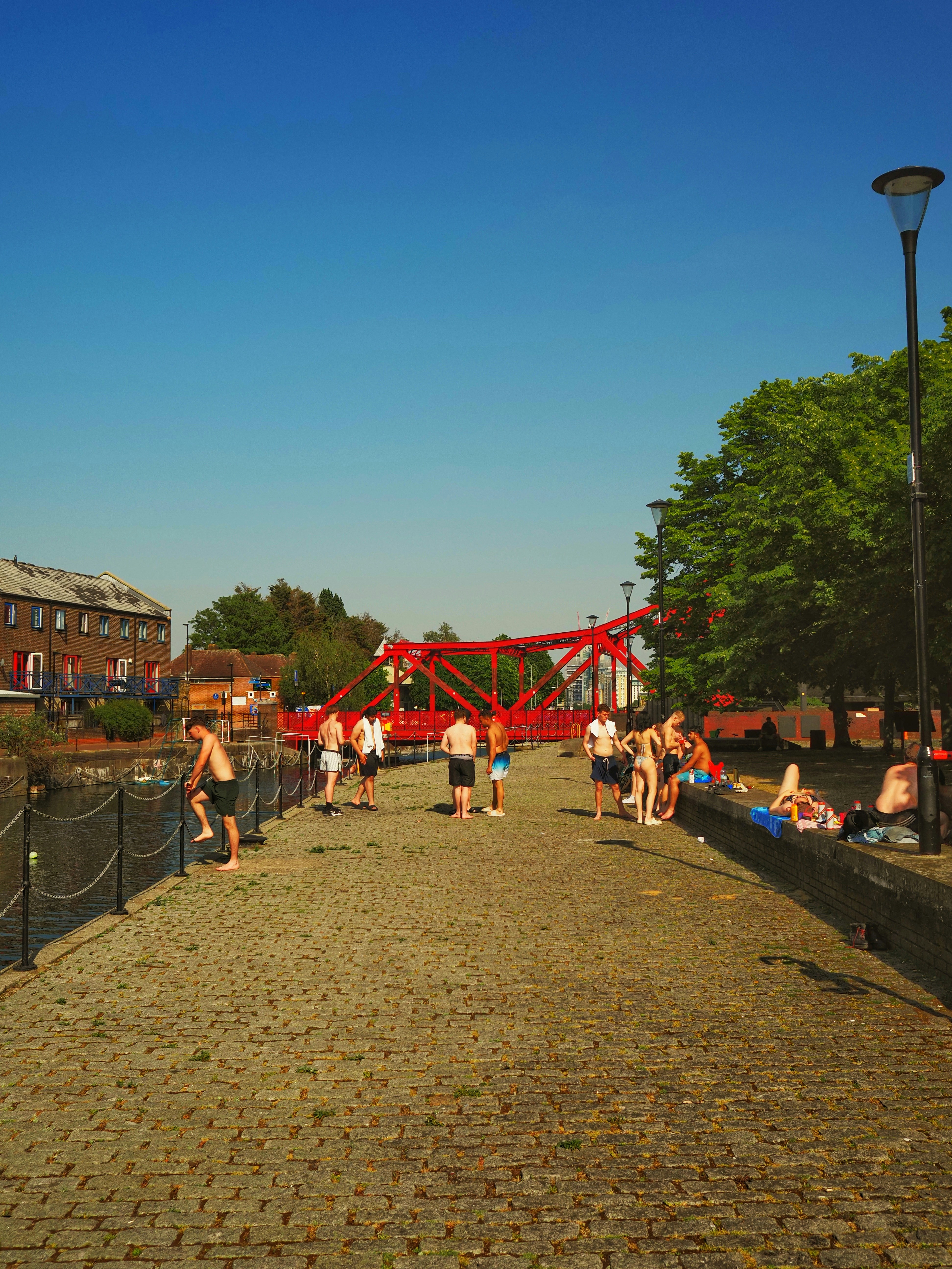 Sunlit Riverside Crowd at the Red Bridge