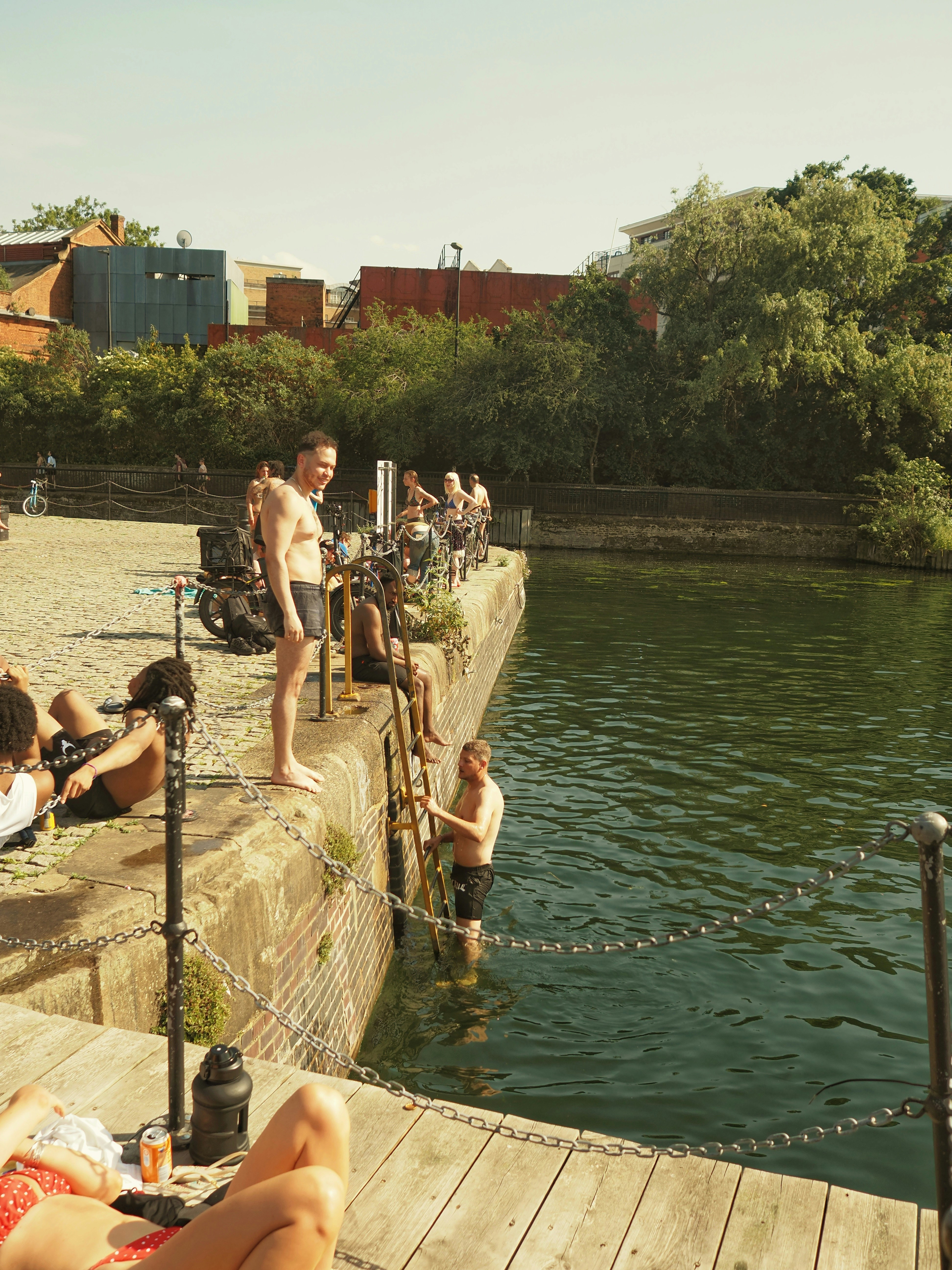 Rusted ramp and river crowd: summer dip by the quay