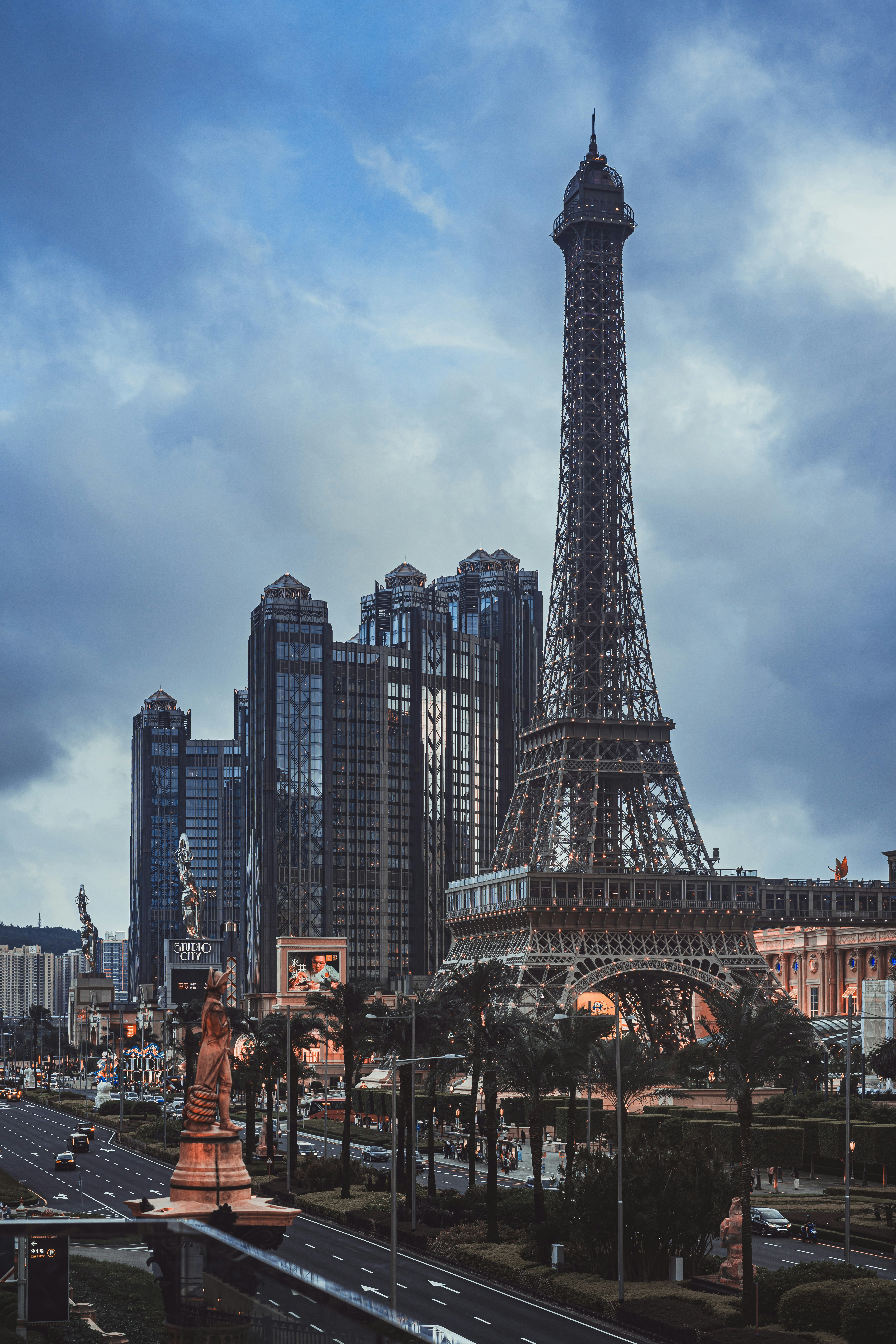Eiffel Towers and Neon Grid: Las Vegas Skyline Under Clouded Blue