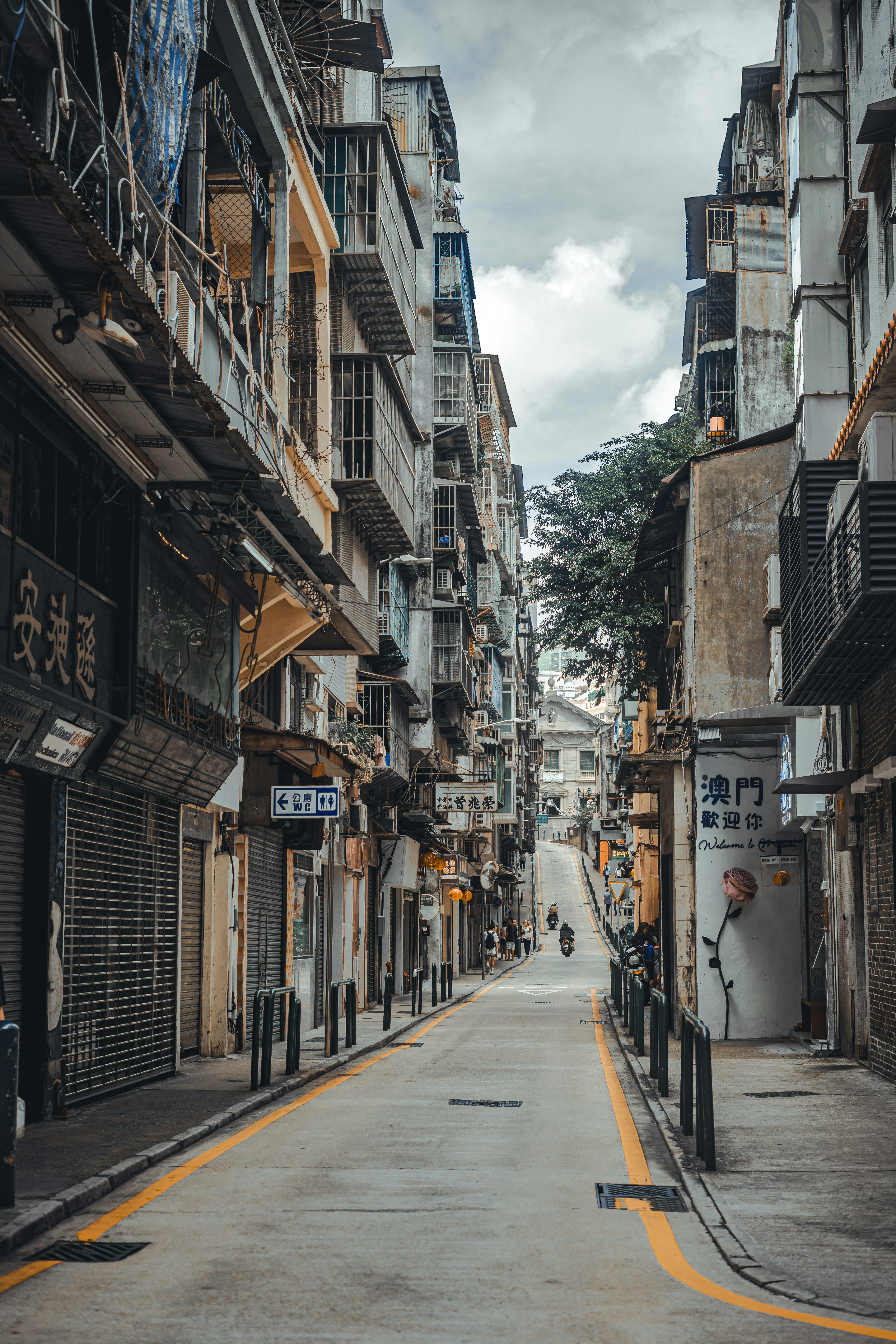 A Narrow Street in the City Between Distant Hills