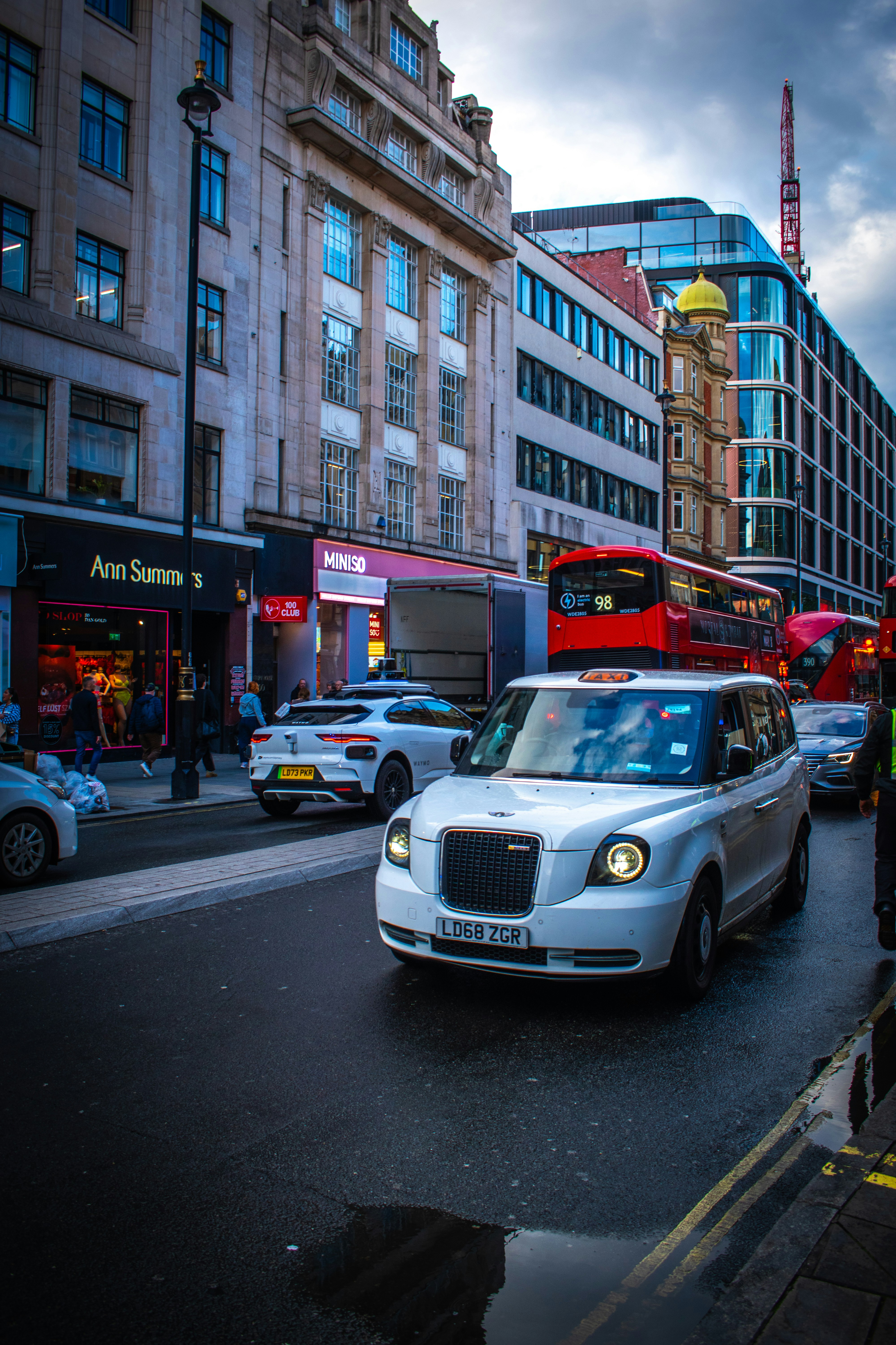 London Street Pulse: A Taxis-and-Red Bus Crawl Through Wet Cobblestones