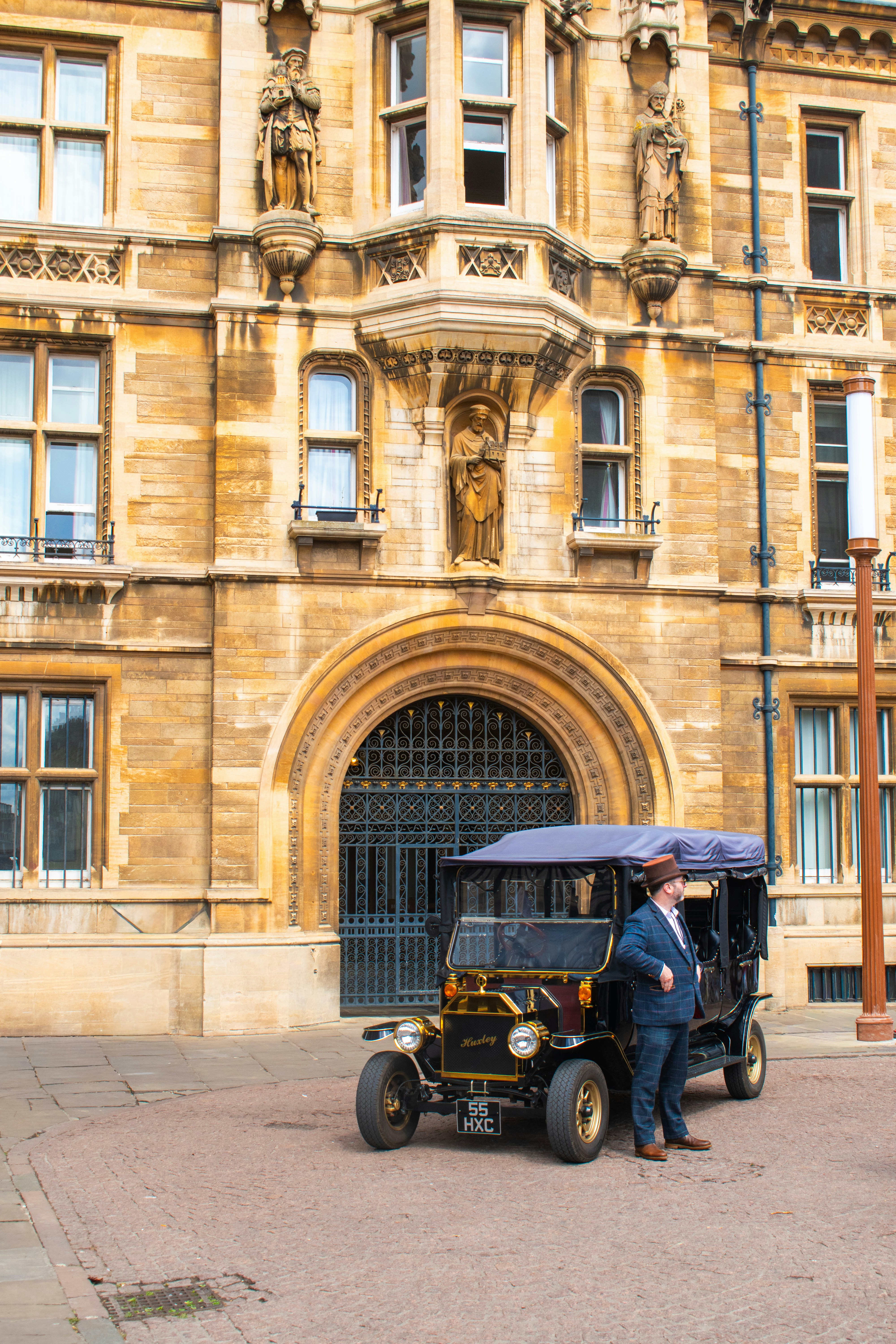 Historic facade and vintage carriage: a poised gentleman anchors the scene