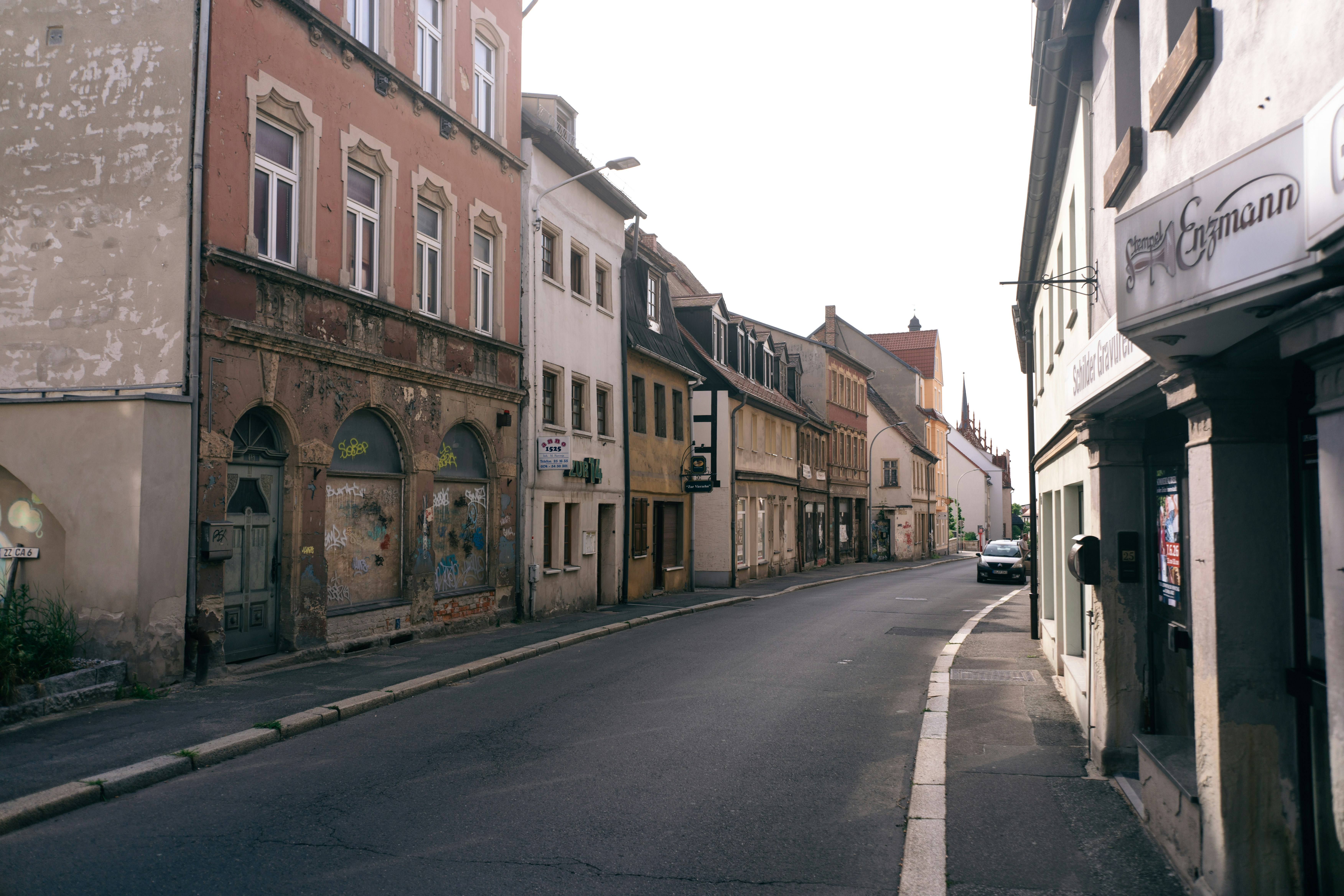 Quiet European Street: Curved Road Toward a Distant Arch