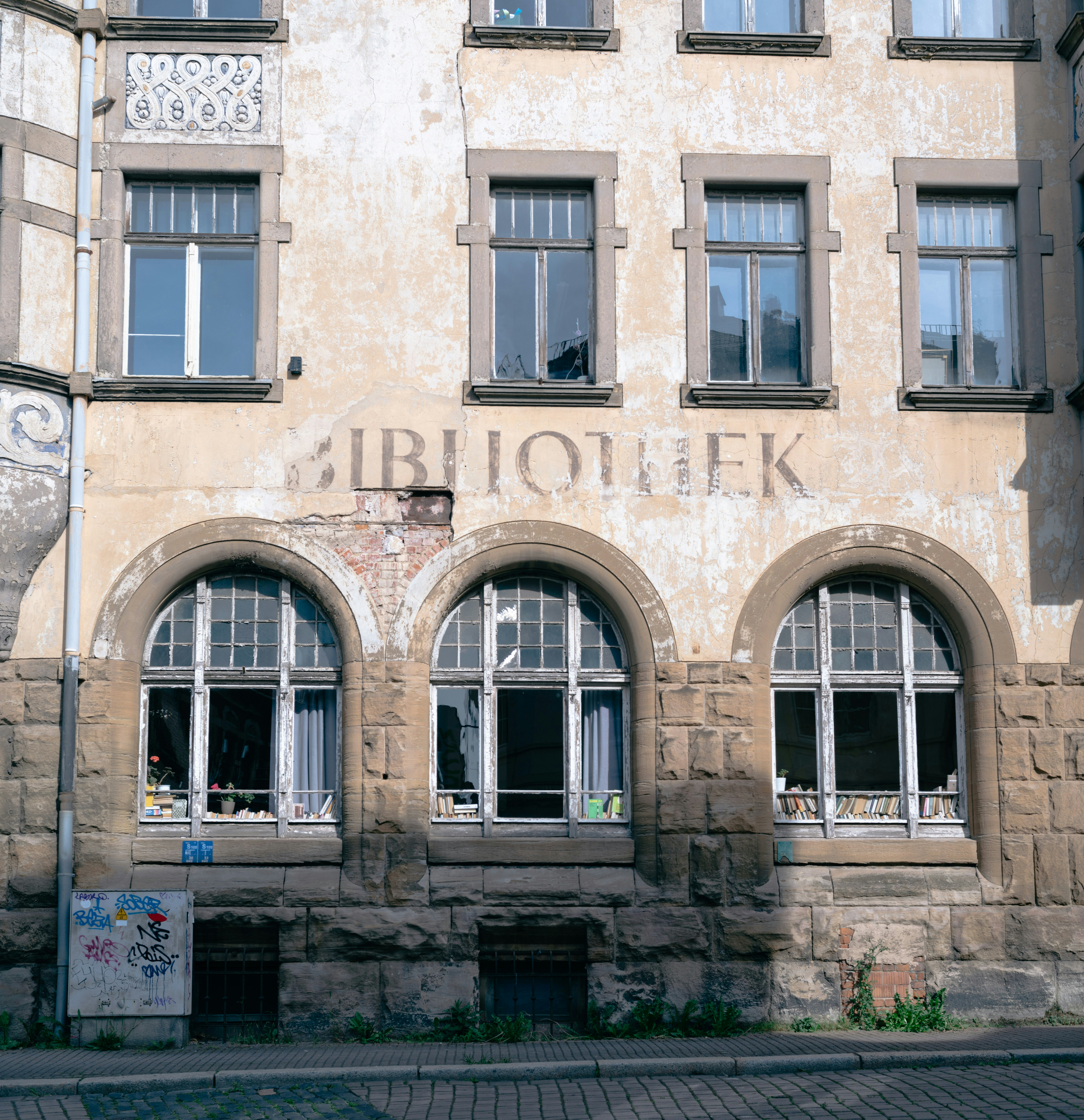 Weathered Library Facade Beneath Faded Inscription