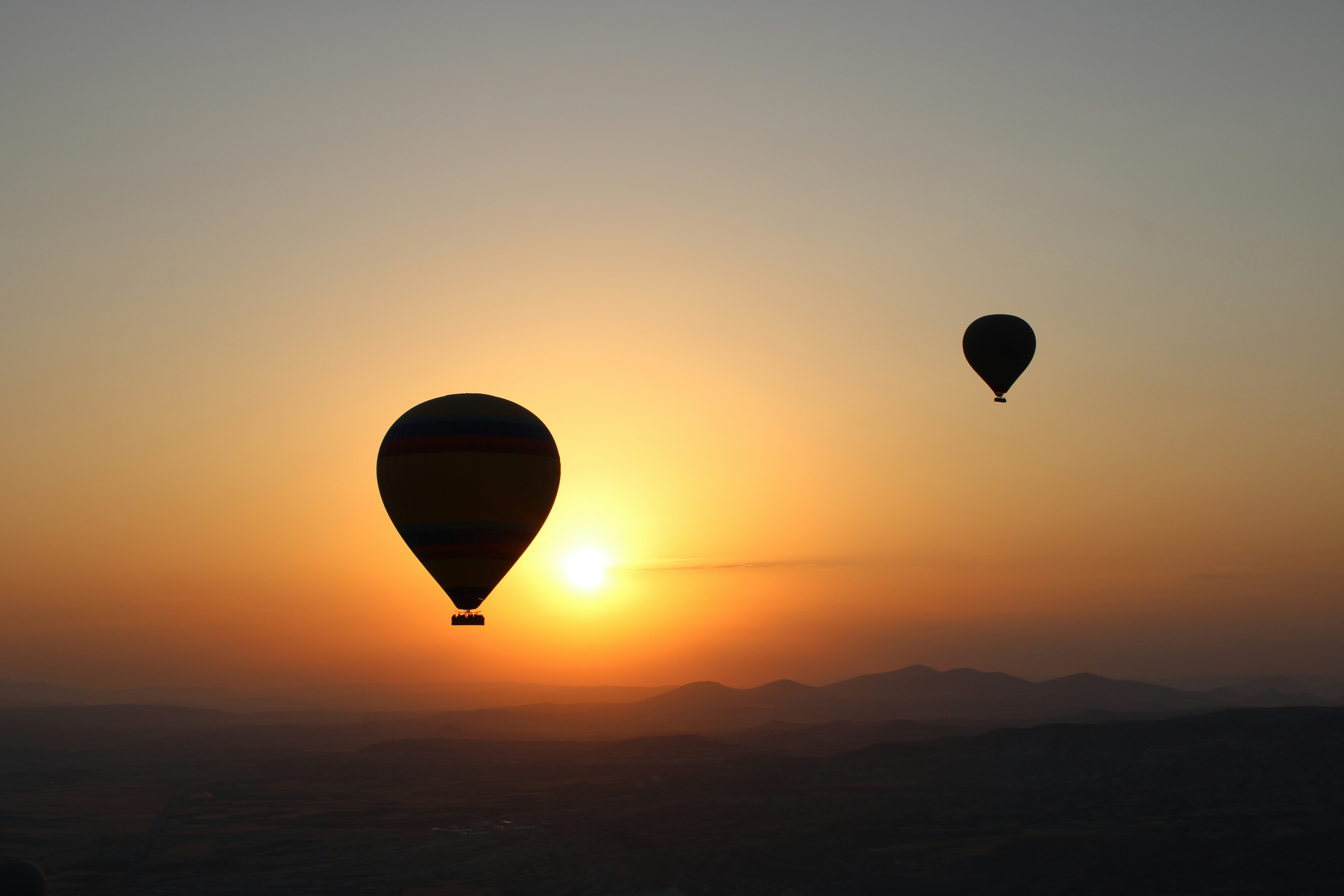 Dawn Descent: Twin Balloons Above a Quiet Horizon