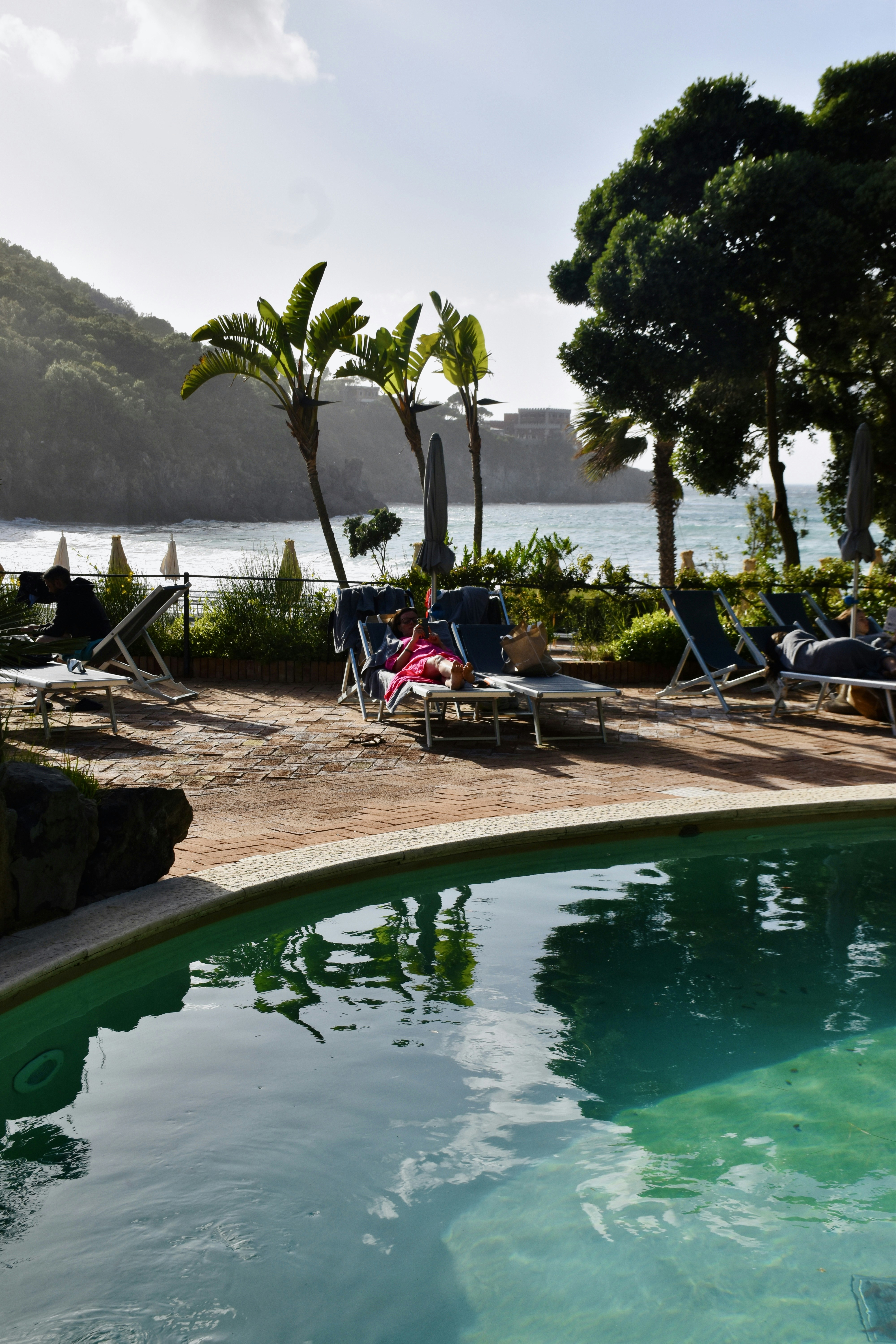 Poolside Retreat at Sunset: Palm Shadows and Ocean Vista