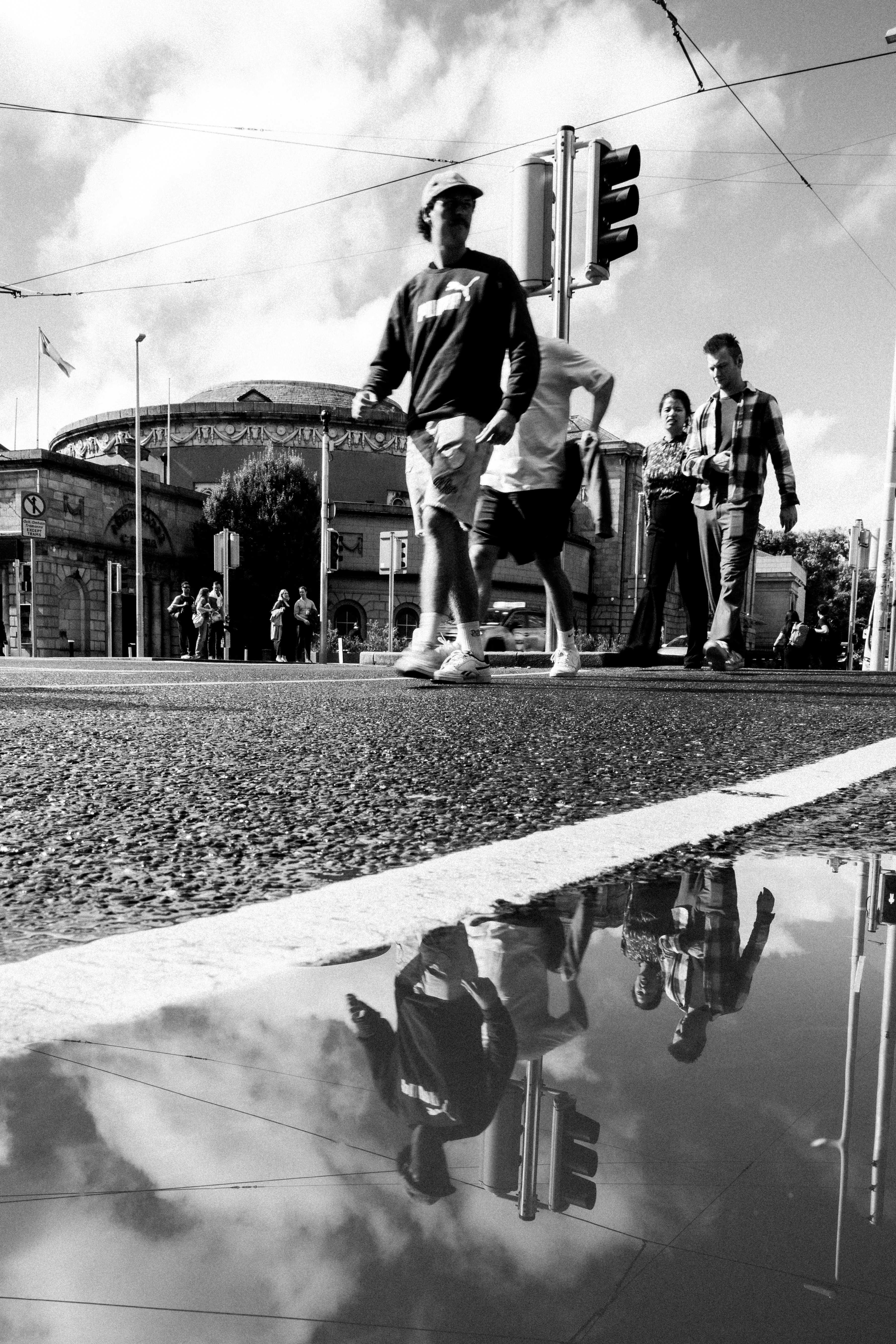 Crosswalk Echoes: People and Reflection at a City Corner