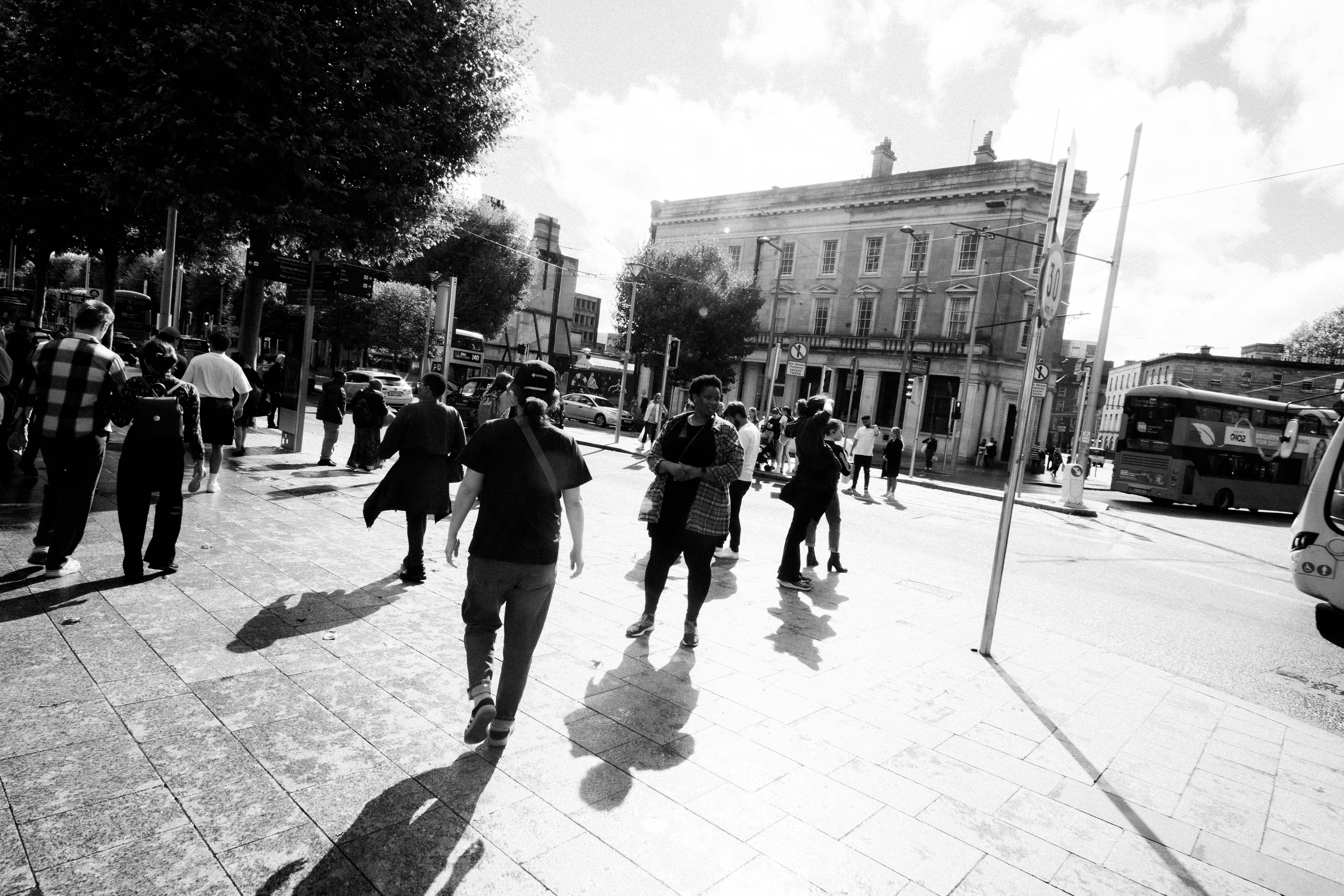 Street Pulse: People Crossing a Sunlit Plaza