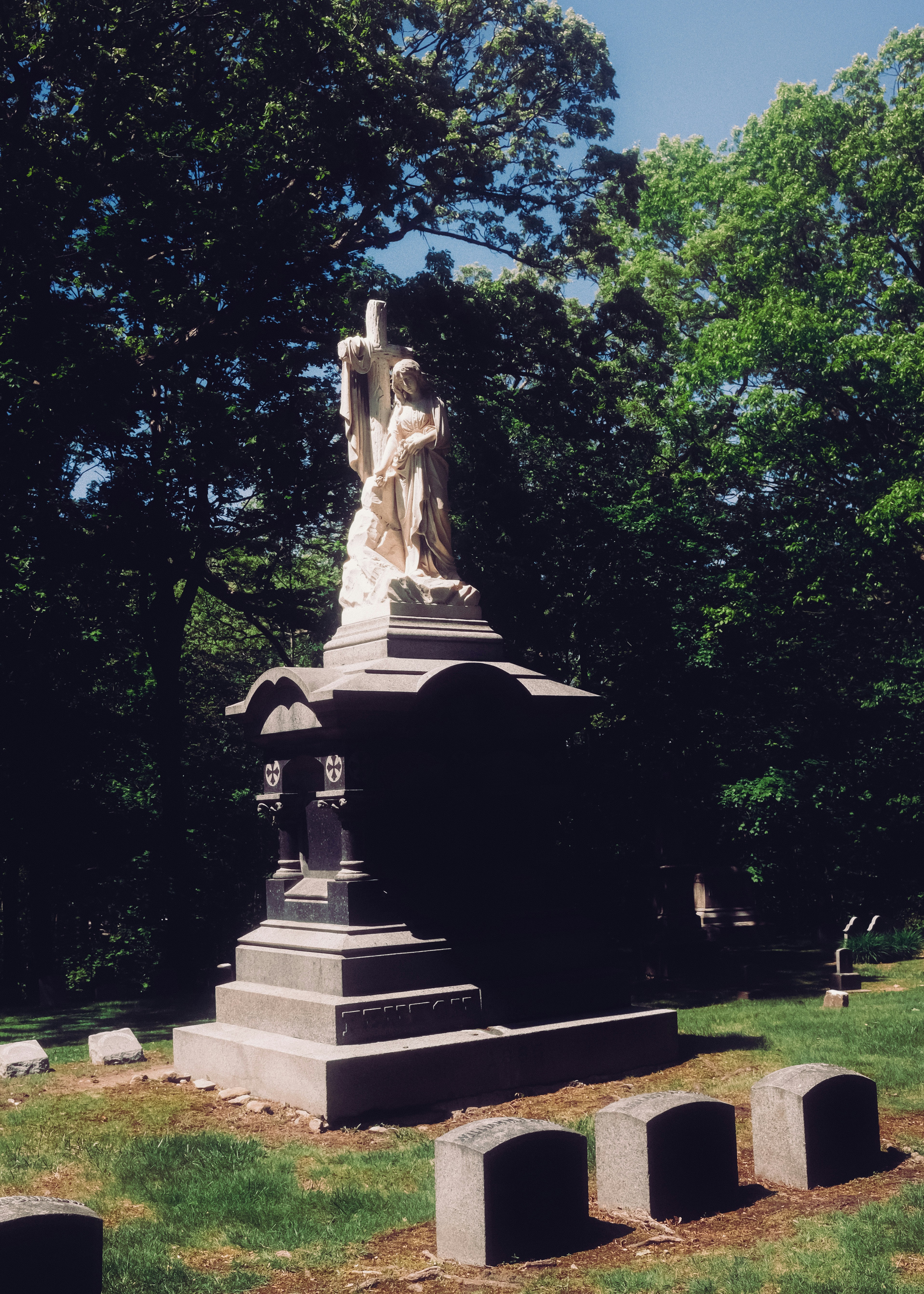 Statue Sentinel: A Monument Amid Dappled Green Light