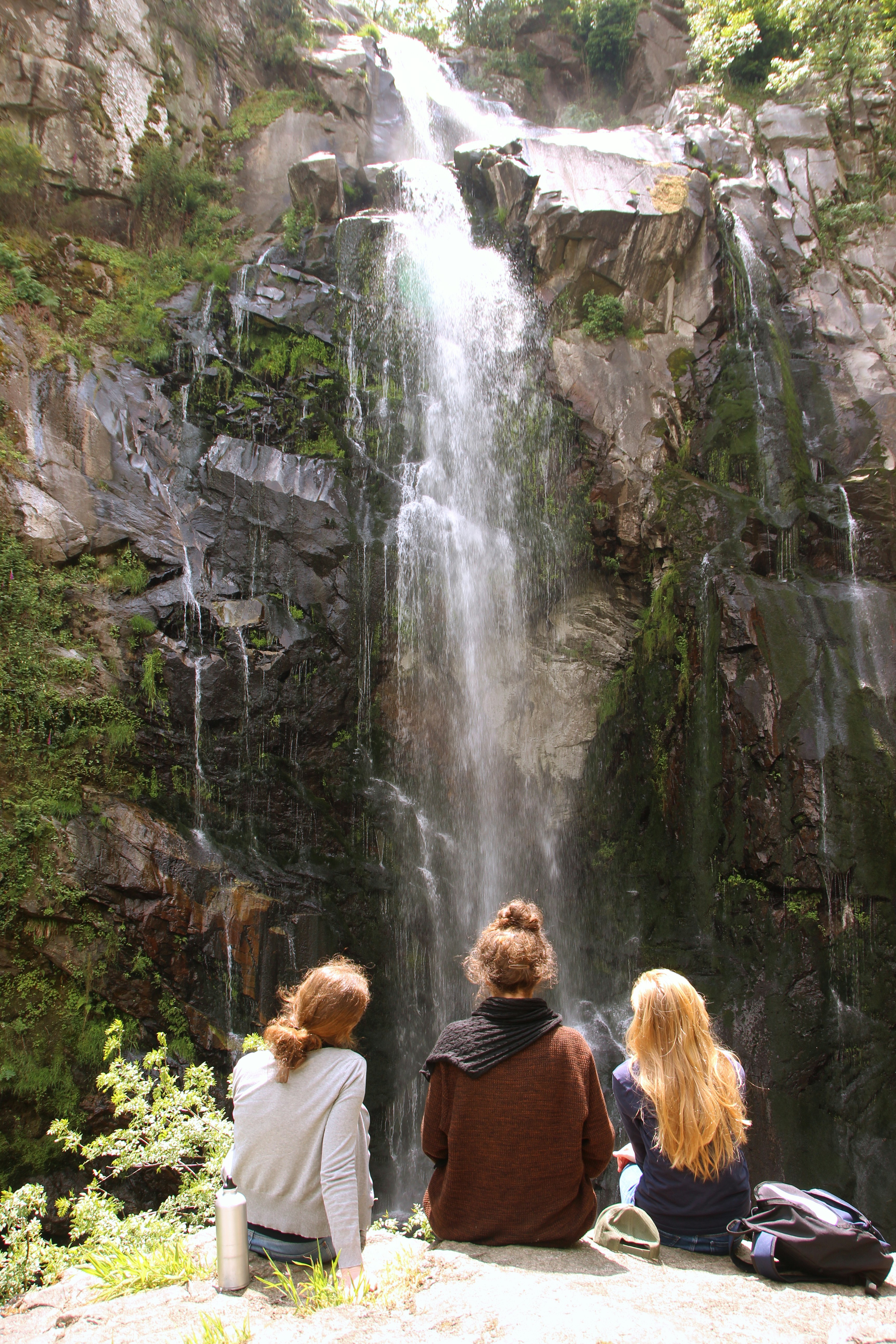 Three Friends Take in a Cascading Cliffside Waterfall