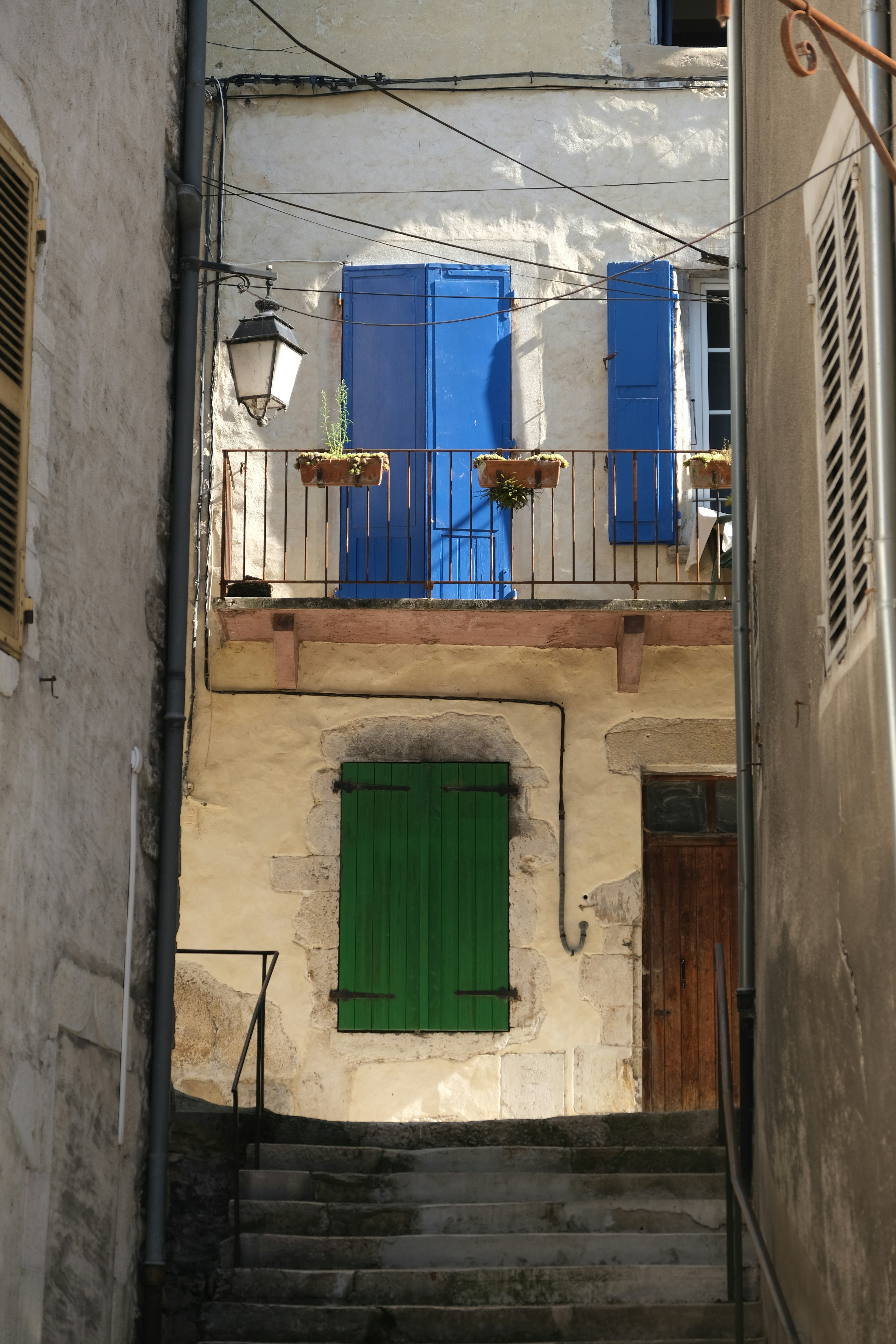 Blue Shutters Over a Narrow Stairway