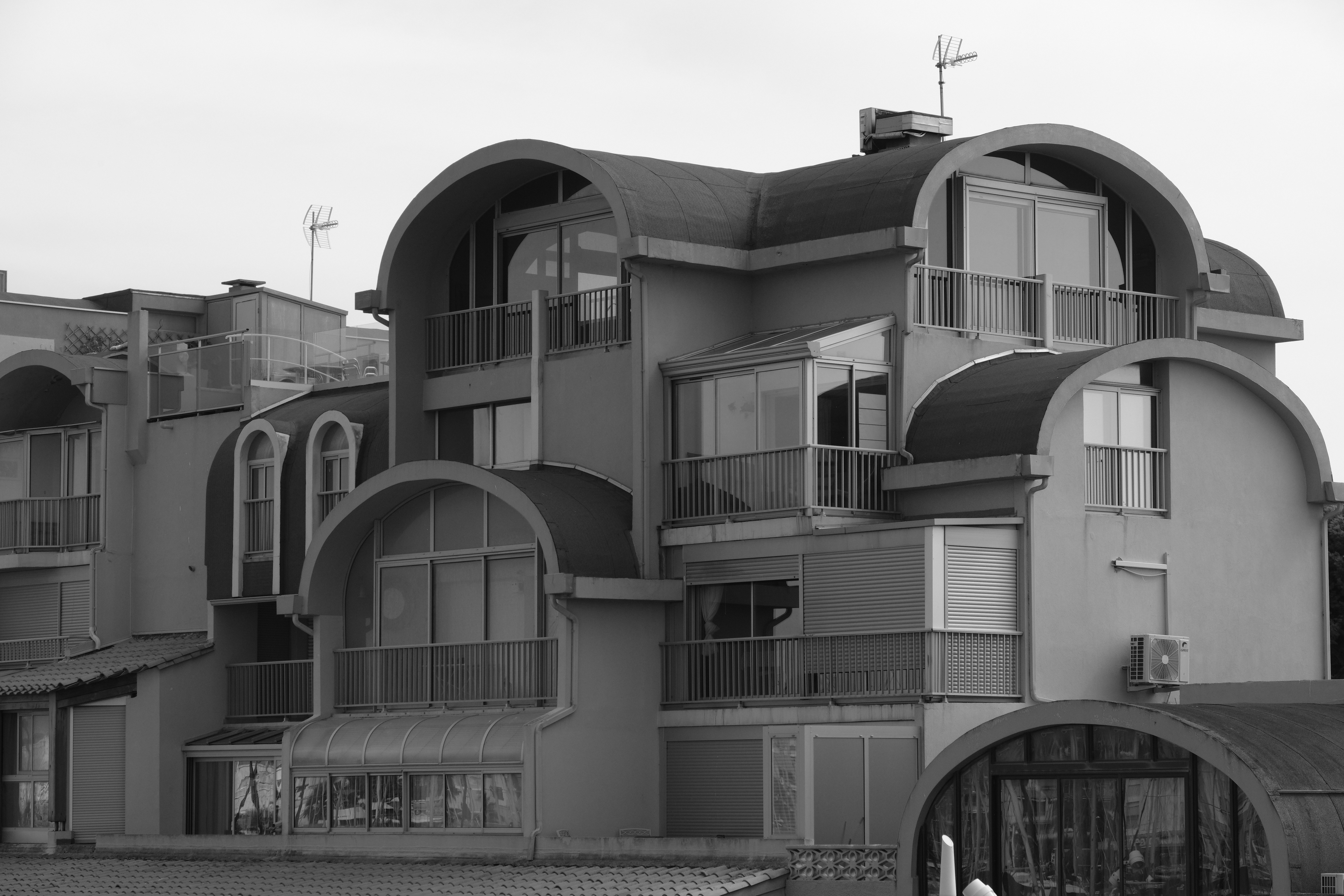 Curved Facades and Concrete Arches: A Quiet Urban Monolith