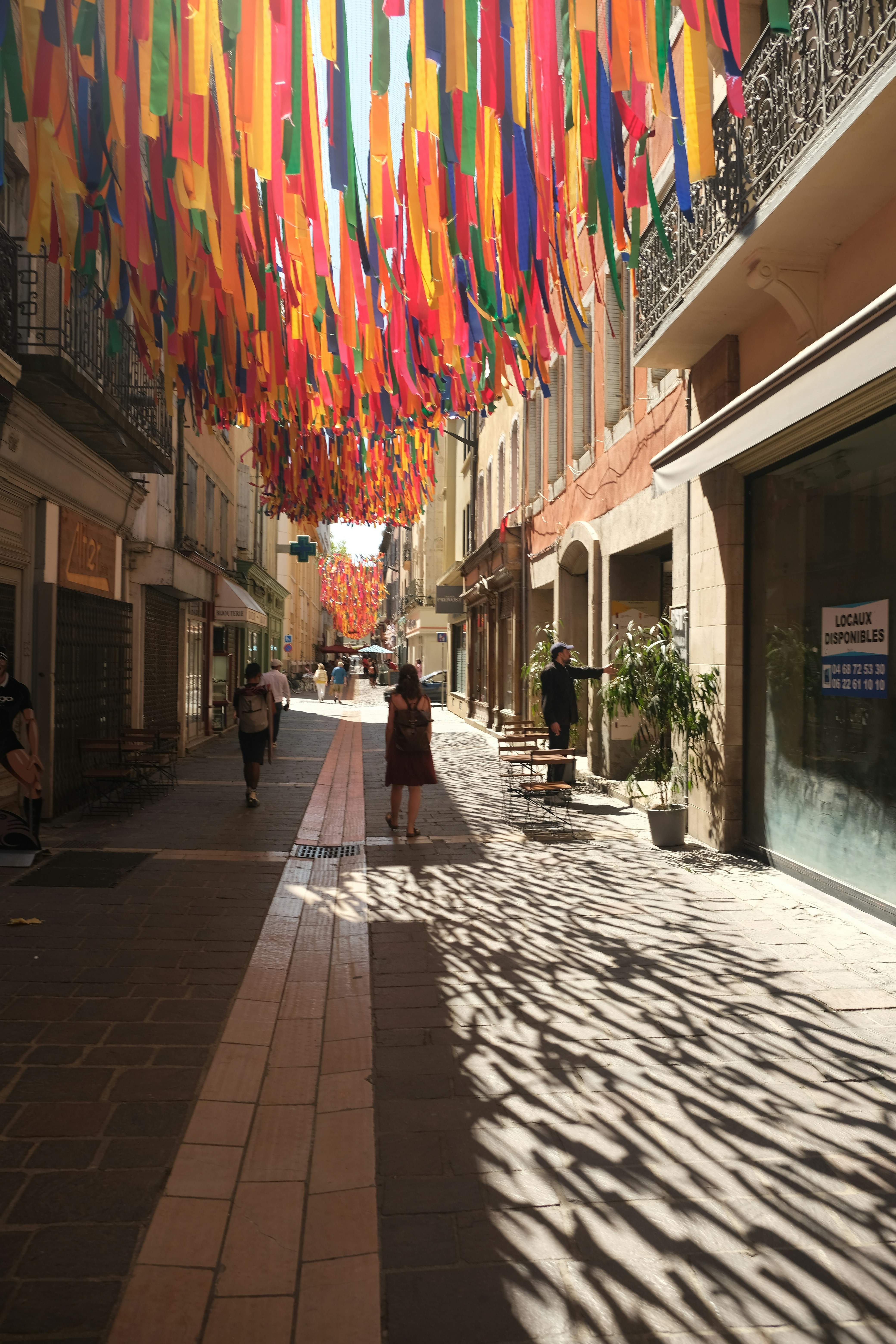 Colorful Street Canopy Over a Sunlit Alleya