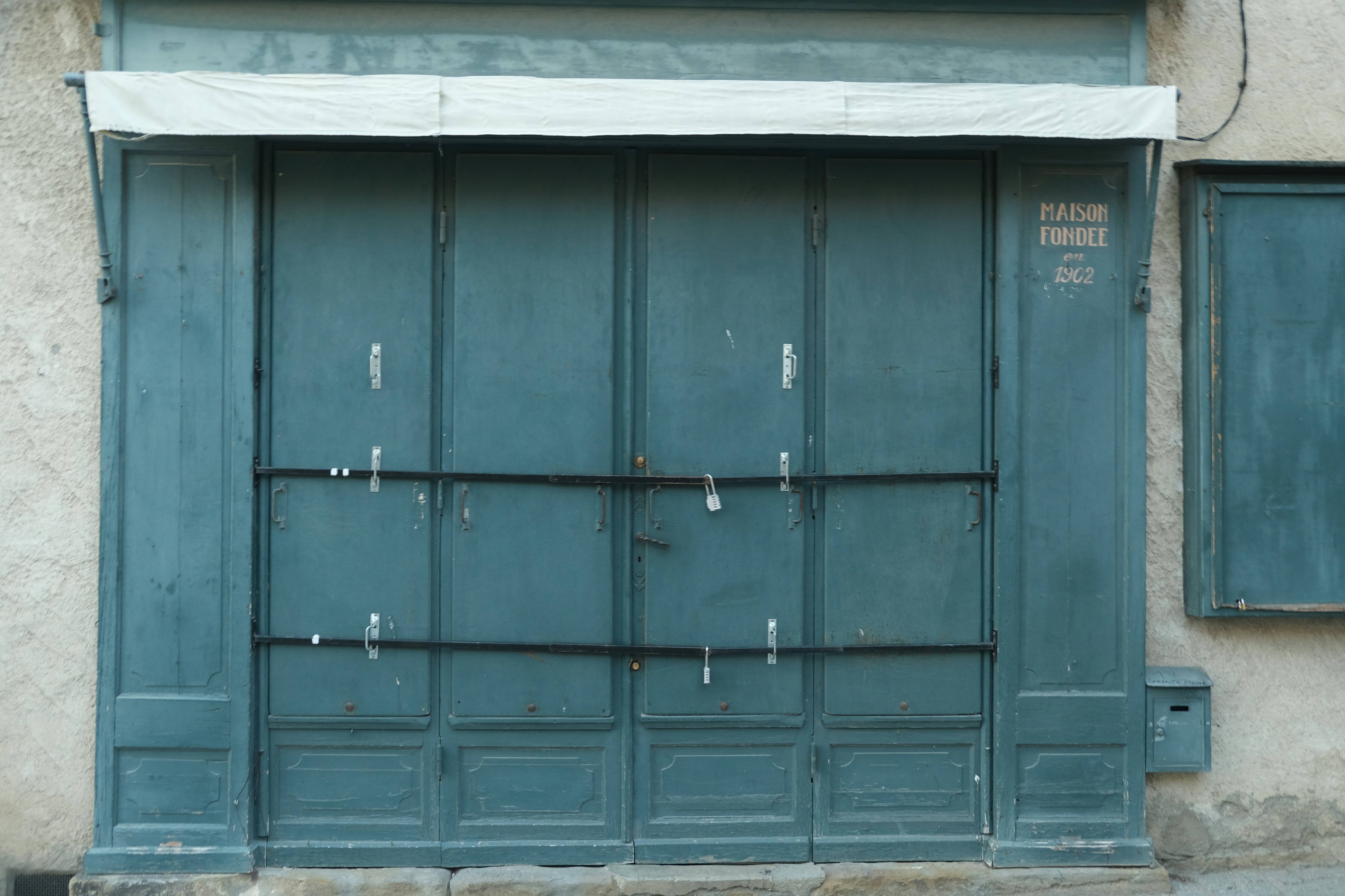 Locked Blue Gate: A Quiet Street Door with Straps and Weathered Texture