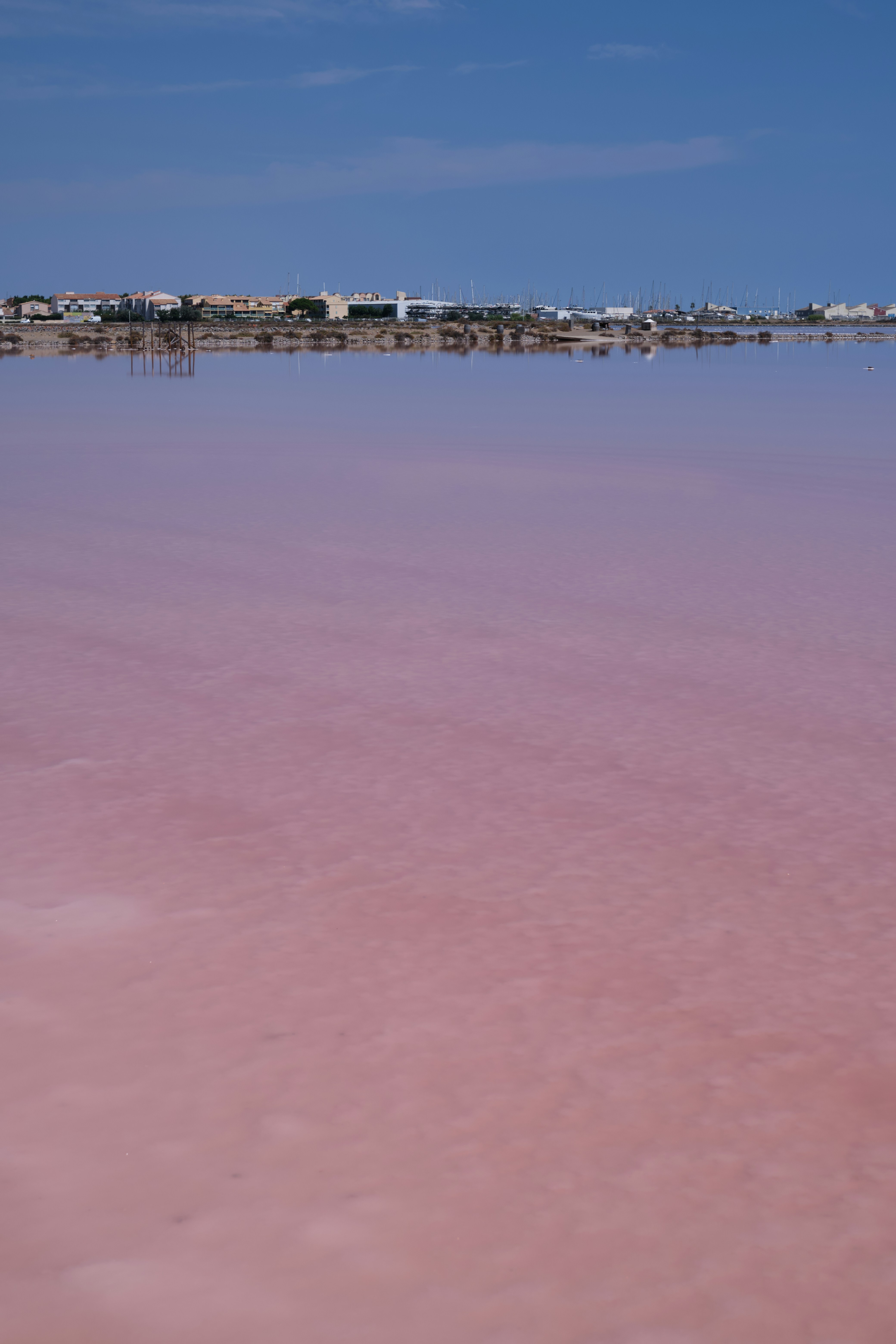 Pink Salt Flats at Distant Town Horizon