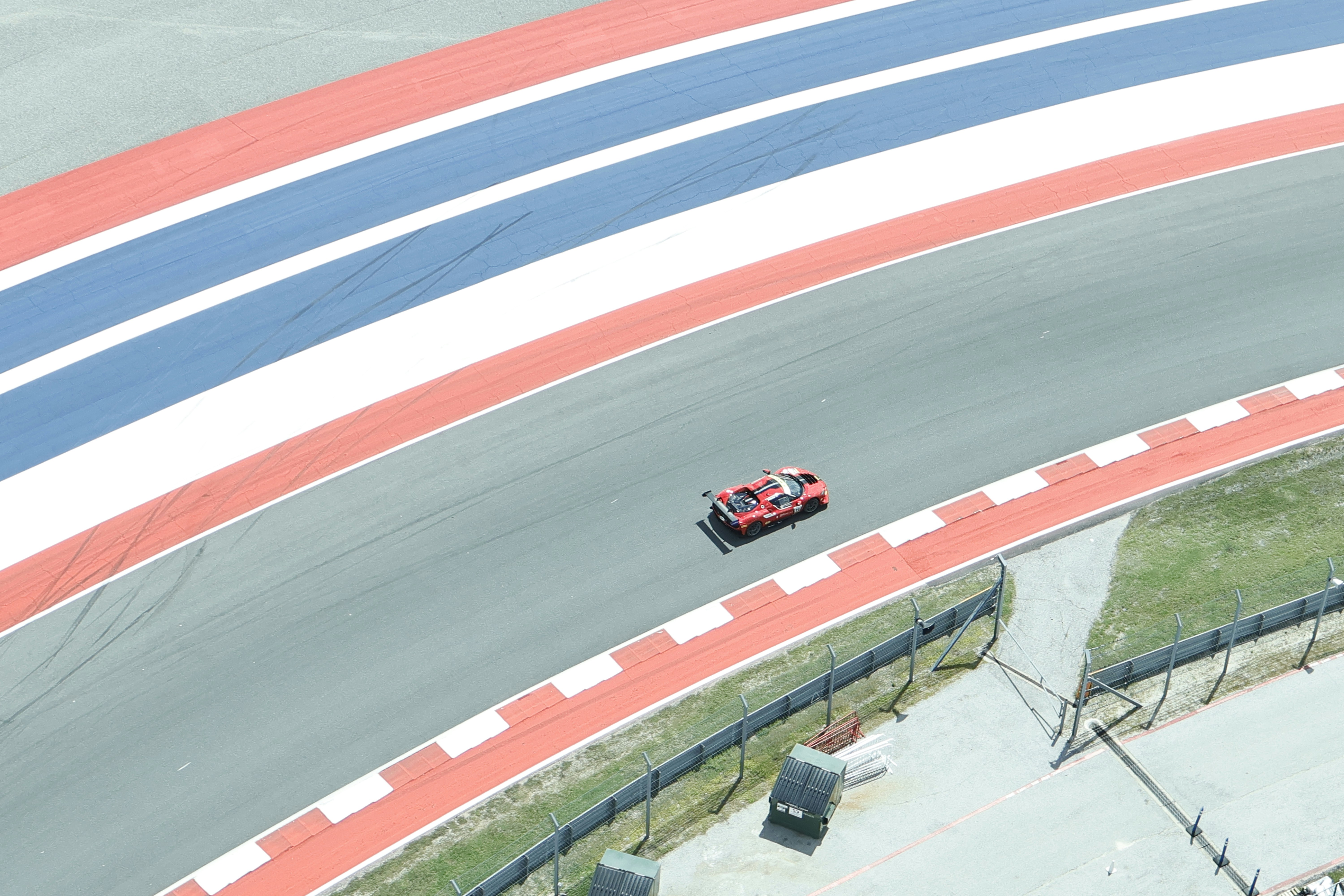 Red Circuit Runner: A solitary car carved along vibrant track stripes