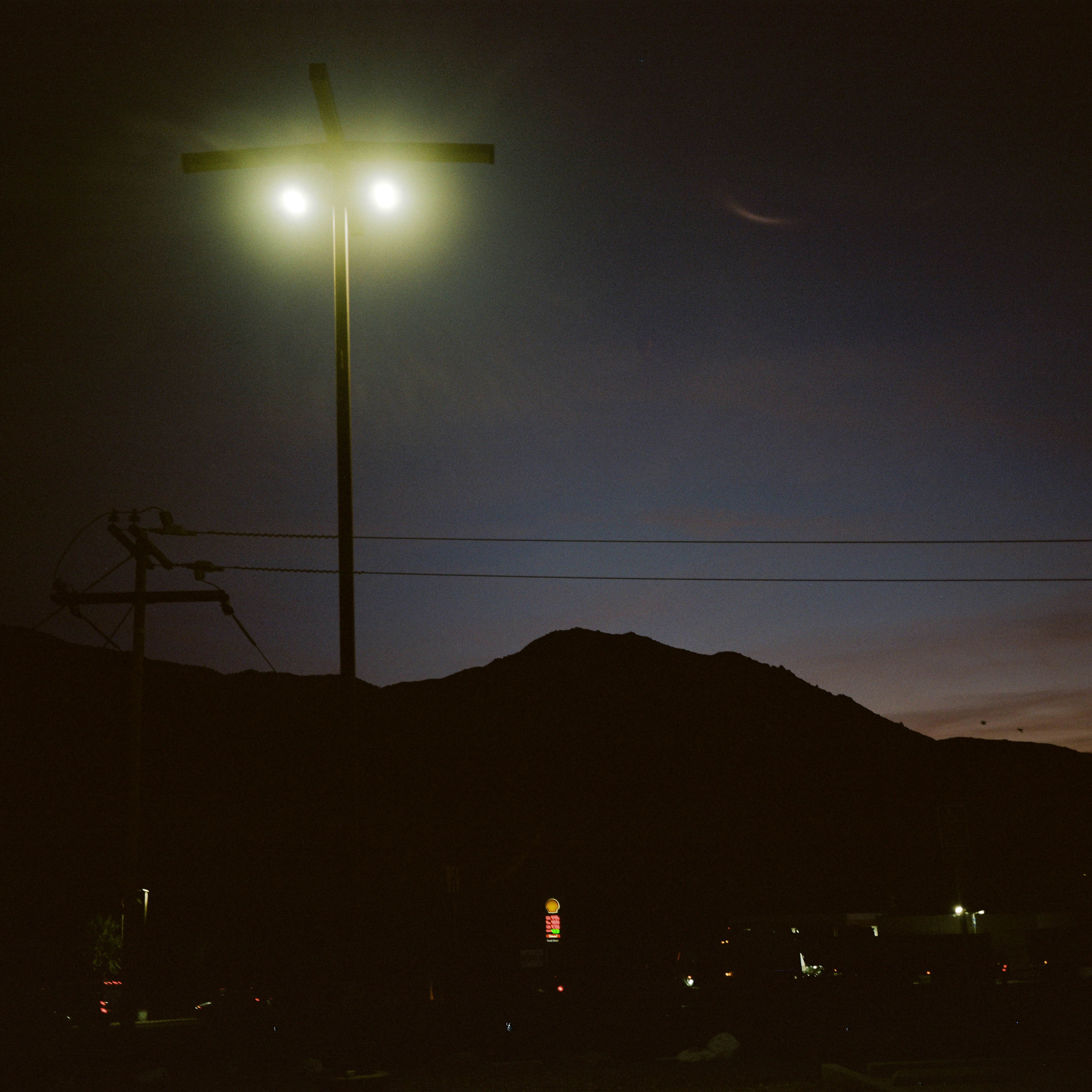 Night Standoff: A Lone Street Lamp Guards the Quiet Hills