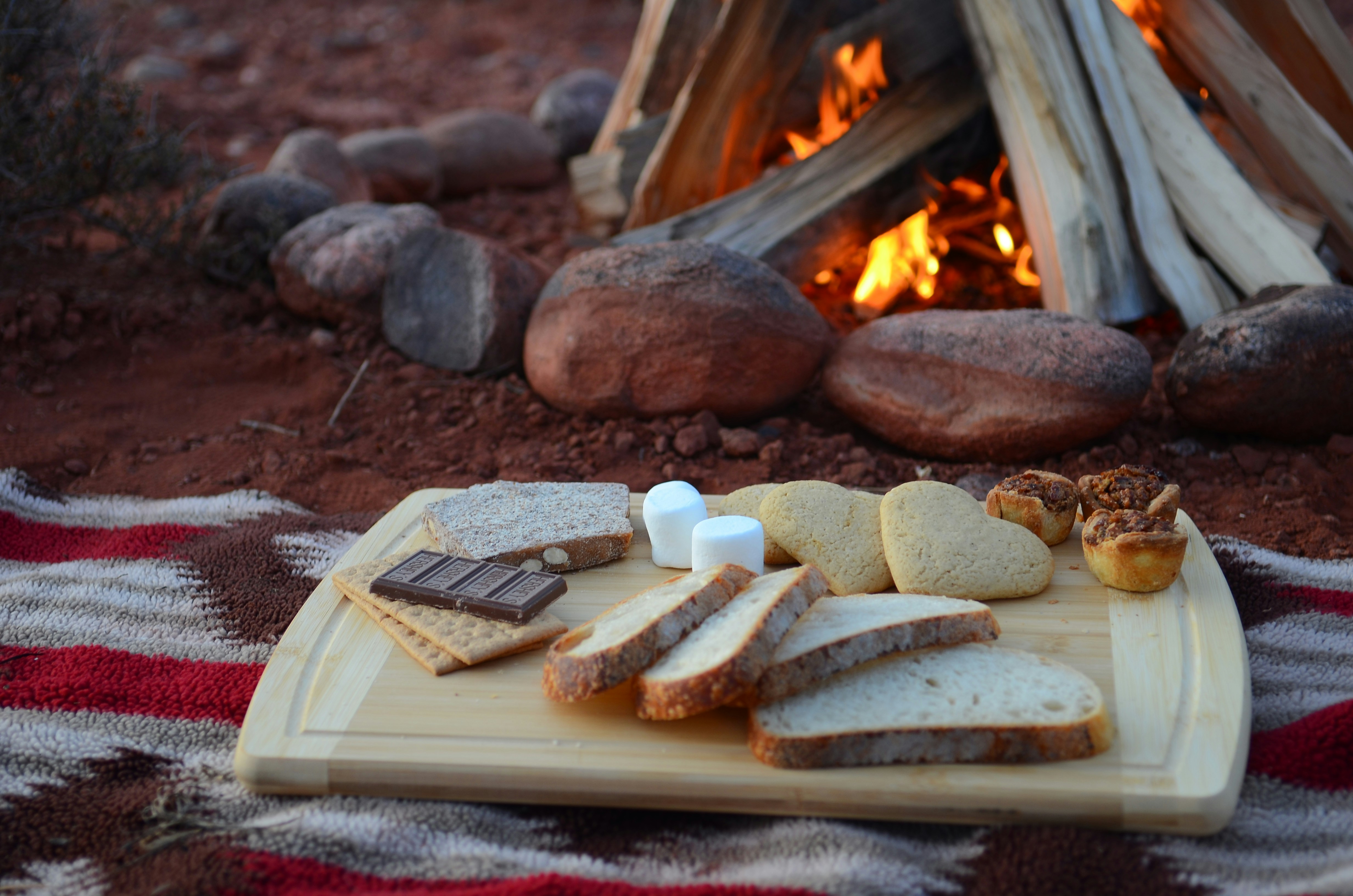 Charcuterie by the Campfire: Sliced Bread and Snacks under Rustic Flame