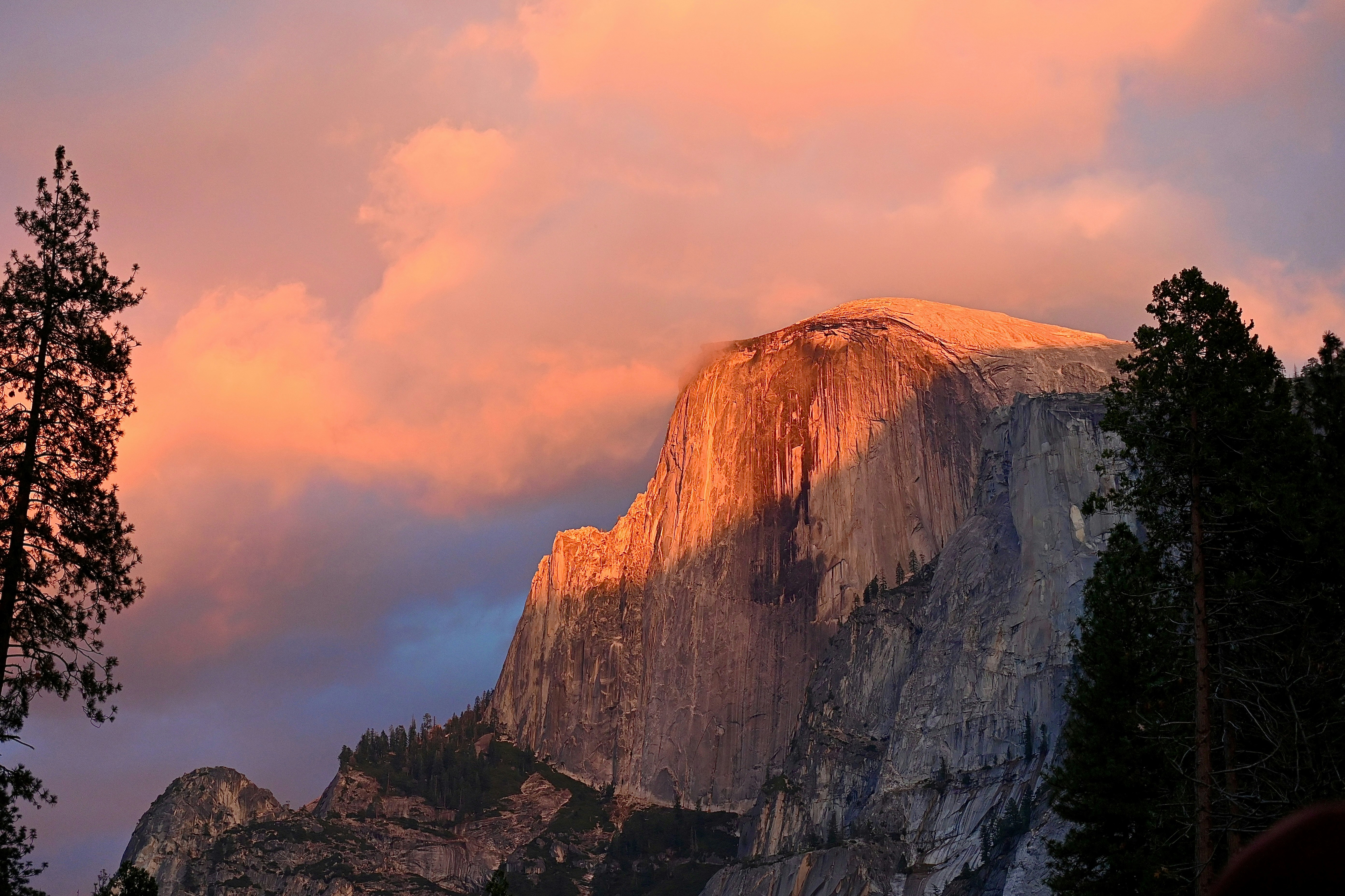 Sunlit Dome: The Granite Peak Crowned in Golden Clouds