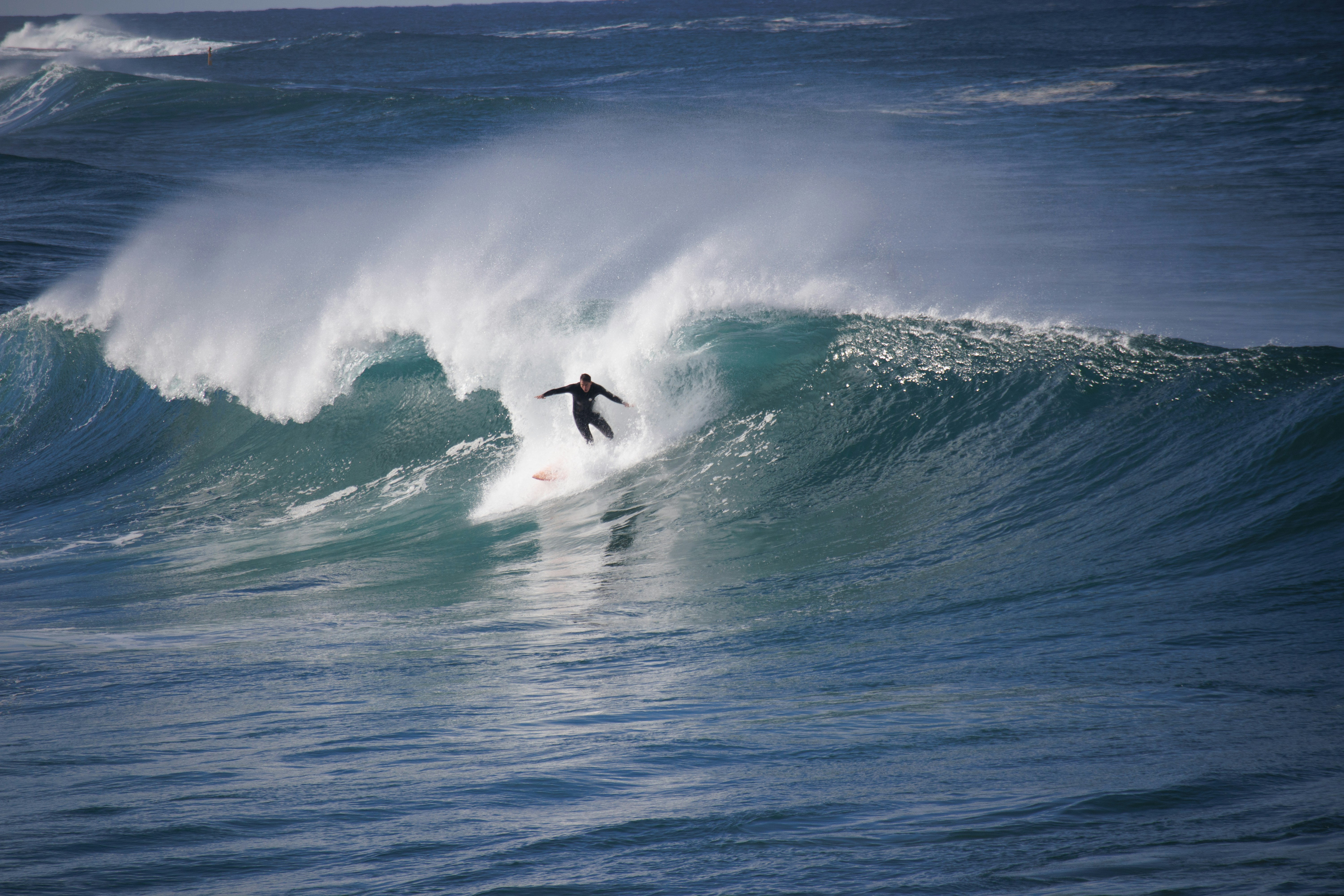 Rider in the Crest: a lone surfer carving a turquoise wall