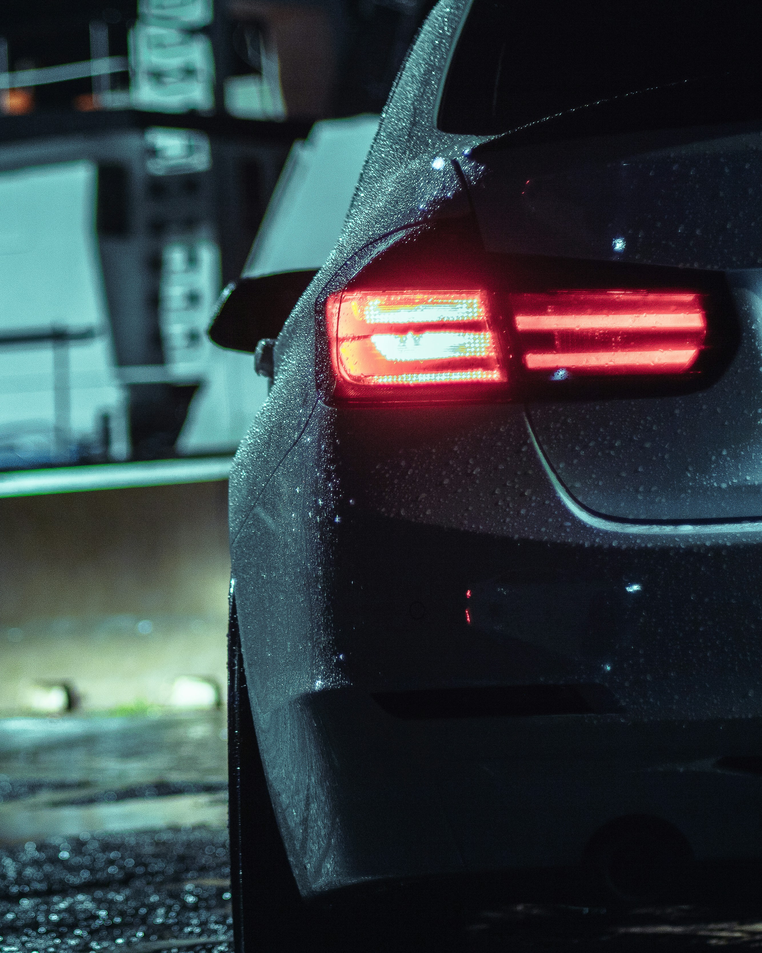 Rear Light in Rain: Neon Crimson on a Wet Midnight Drive