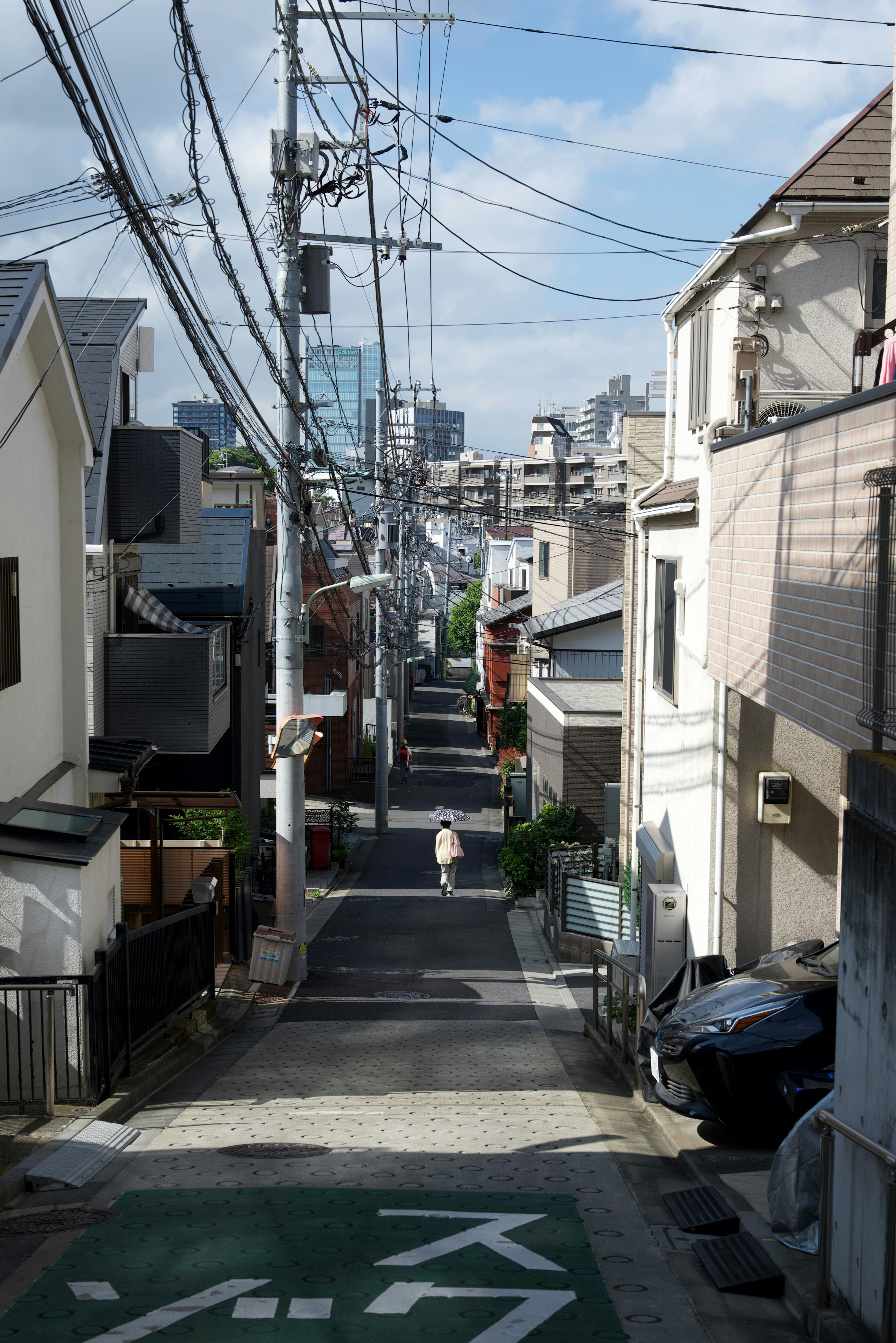Urban Quiet: A Lone Pedestrian Down a Sunlit Japanese Alley