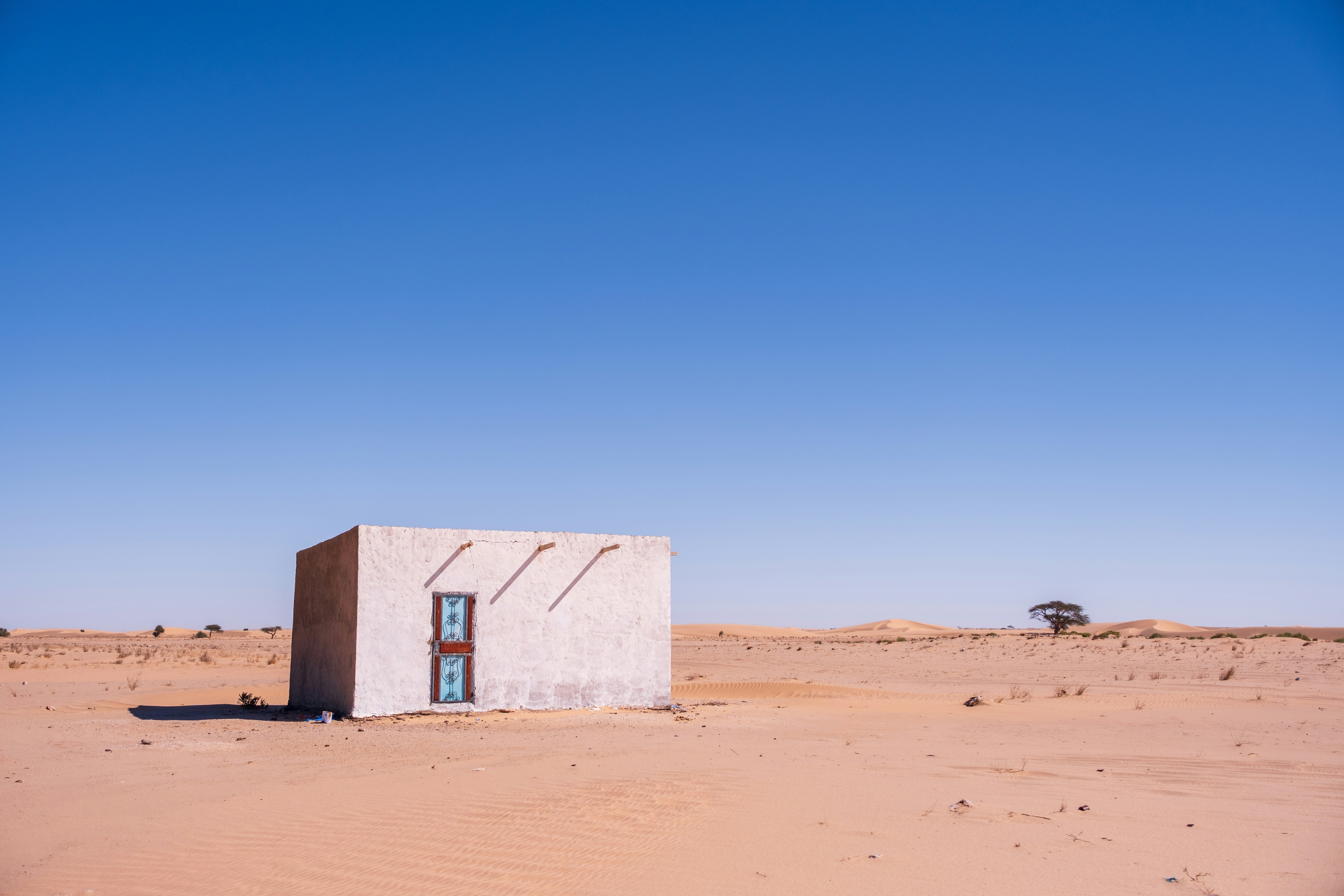 Desert Cuboid: A lone concrete hut under an endless blue sky