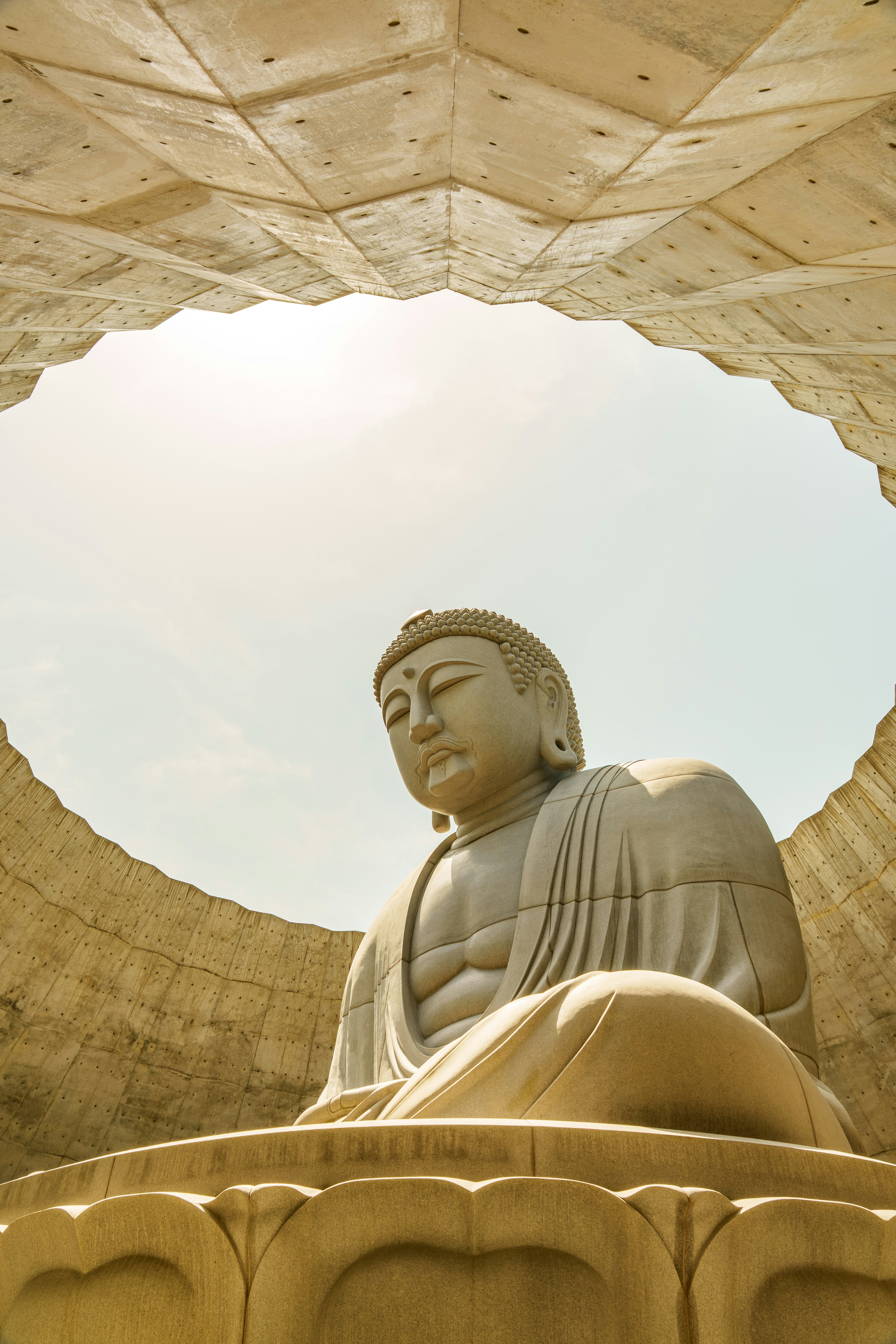 Buddha Amid Circular Sky: A monumental statue framed by an open, sunlit ring