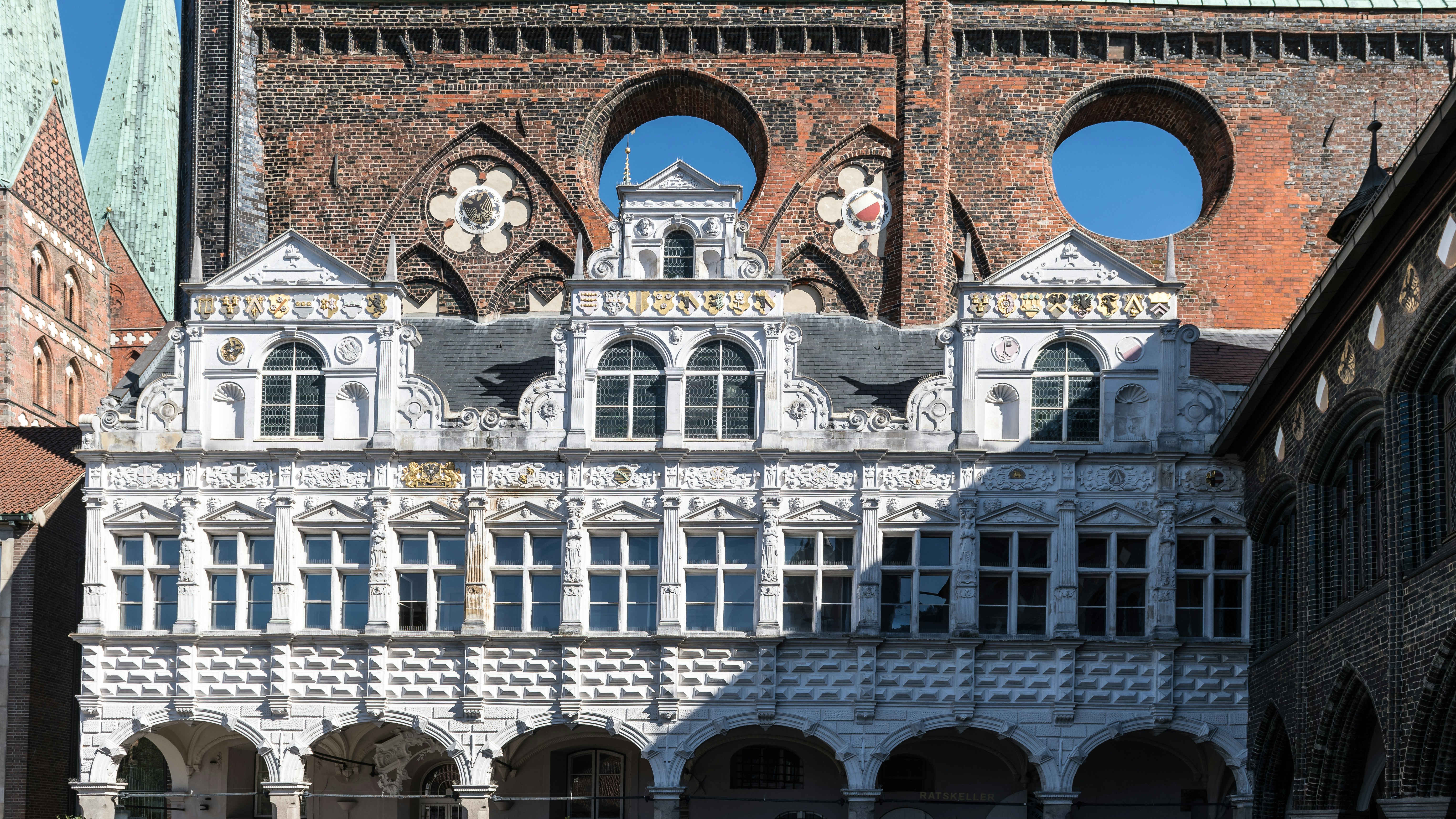 Ornate Facade of White Marble Courtyard Structure Framed by Brick Arches