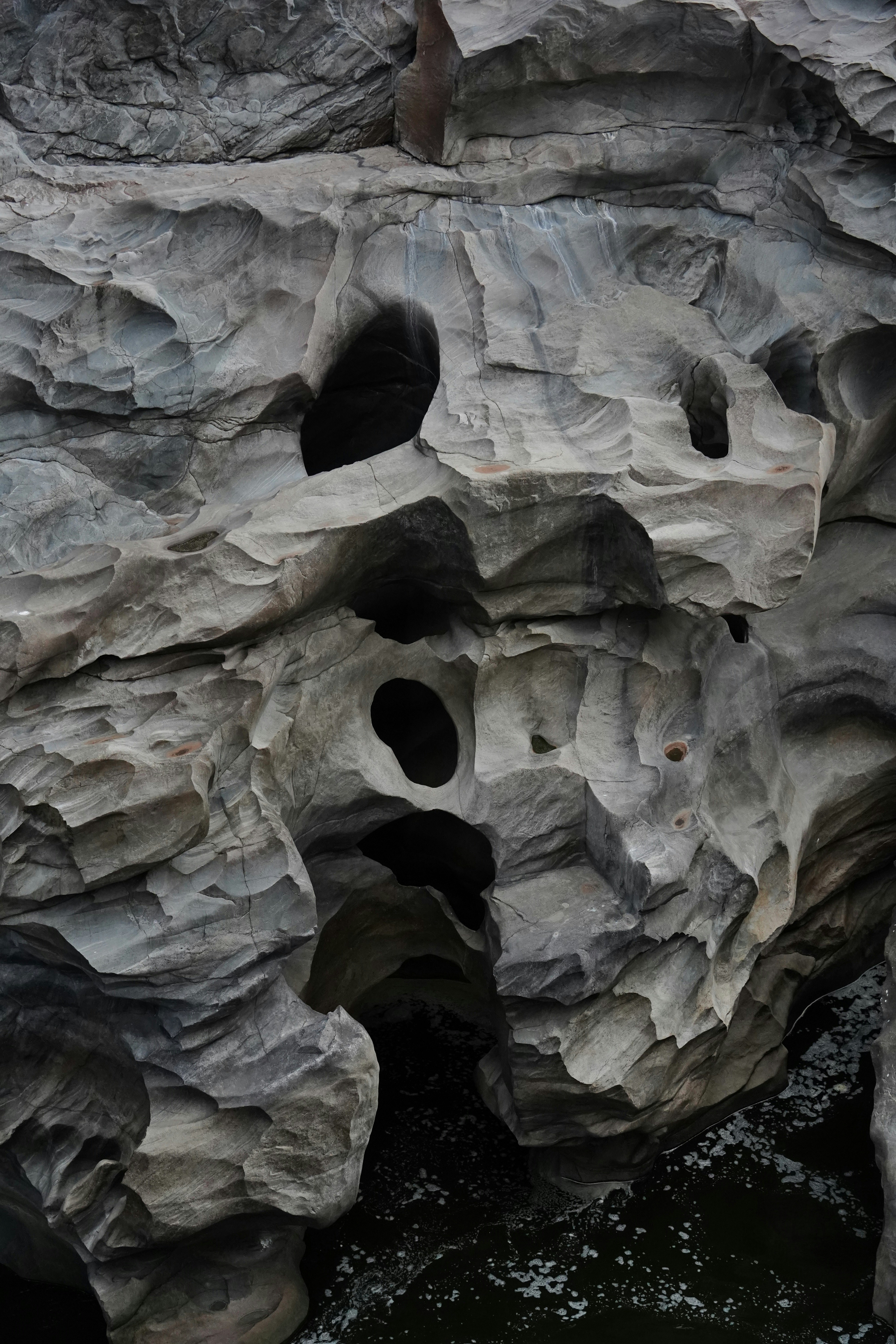 Eroded Faces: A Cascade of Stone Holes Carved by Time