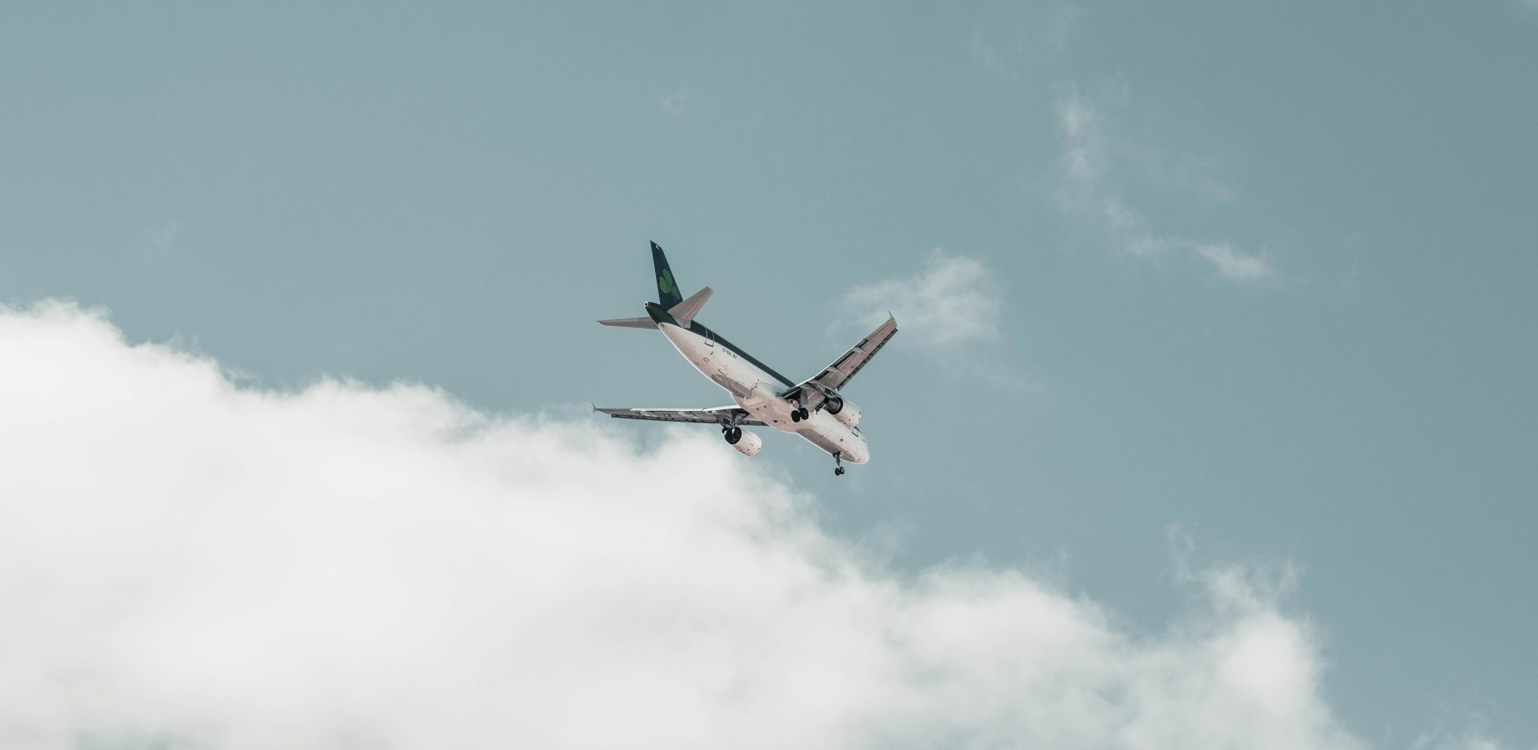 Skybound Lift: A Passenger Jet Ascends Through a Cloudbreak