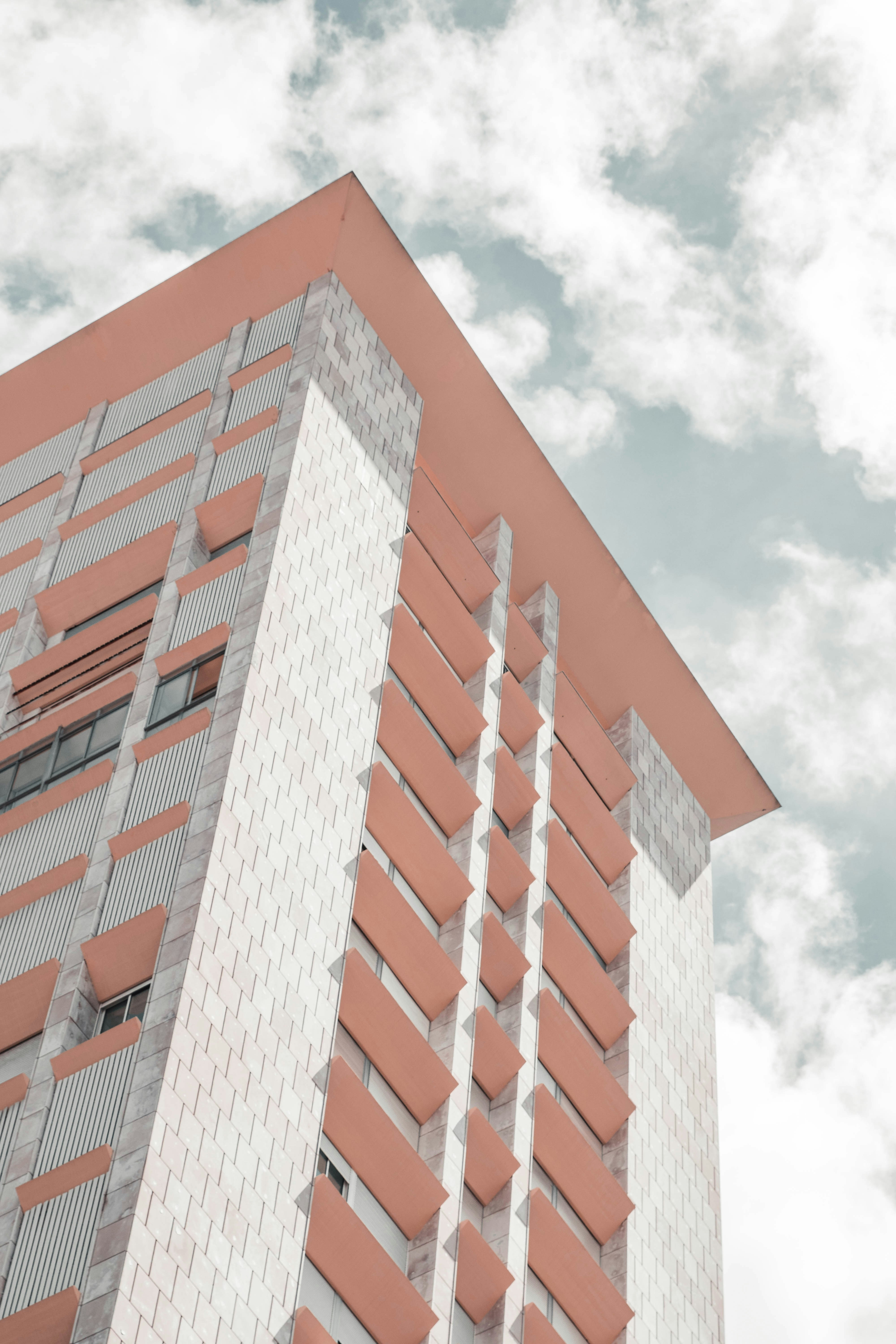 Tower Rising: Facade Geometry Against a Sky of Clouds