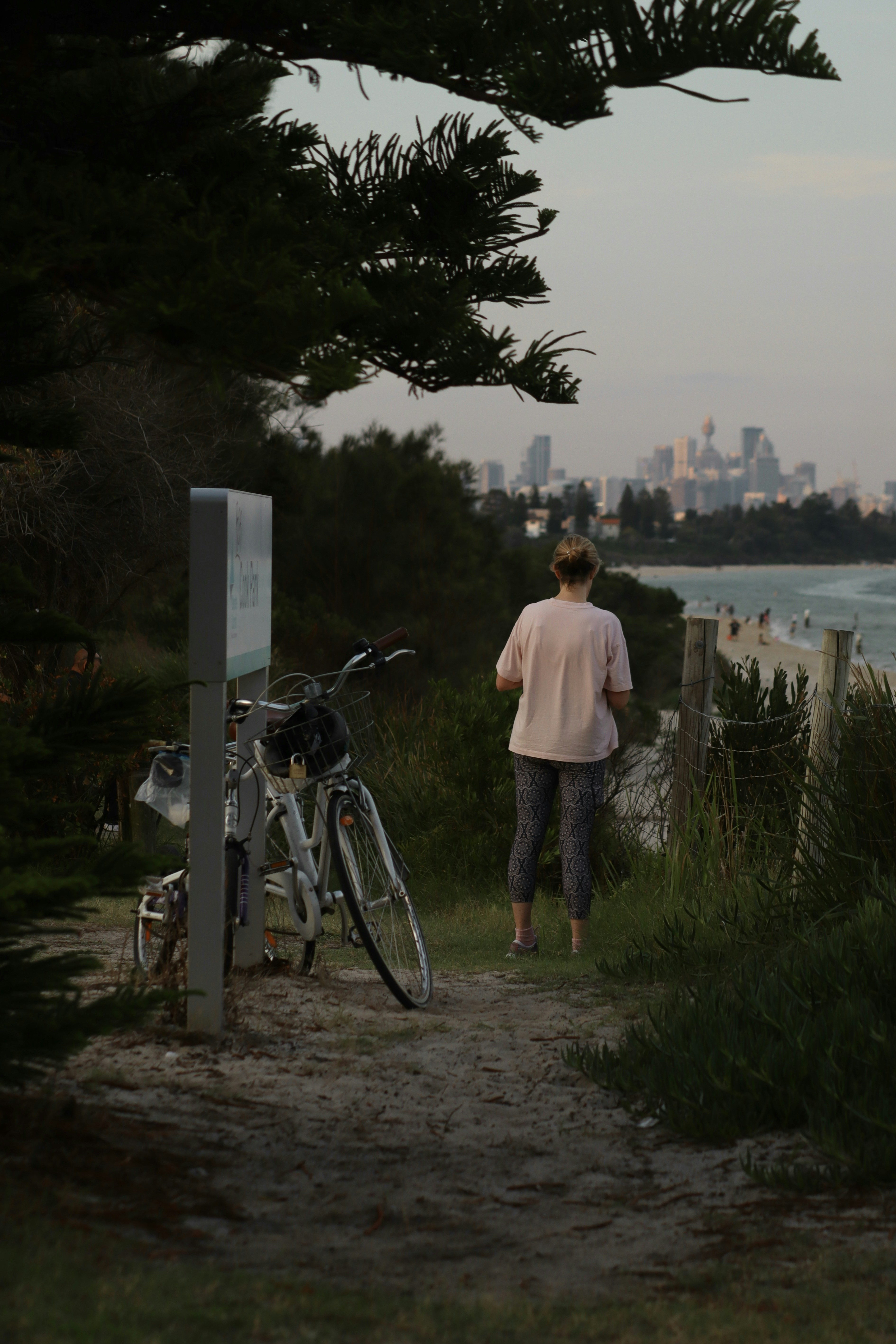 Quiet Walk at Dusk: A Lone Figure by the Seaside Path