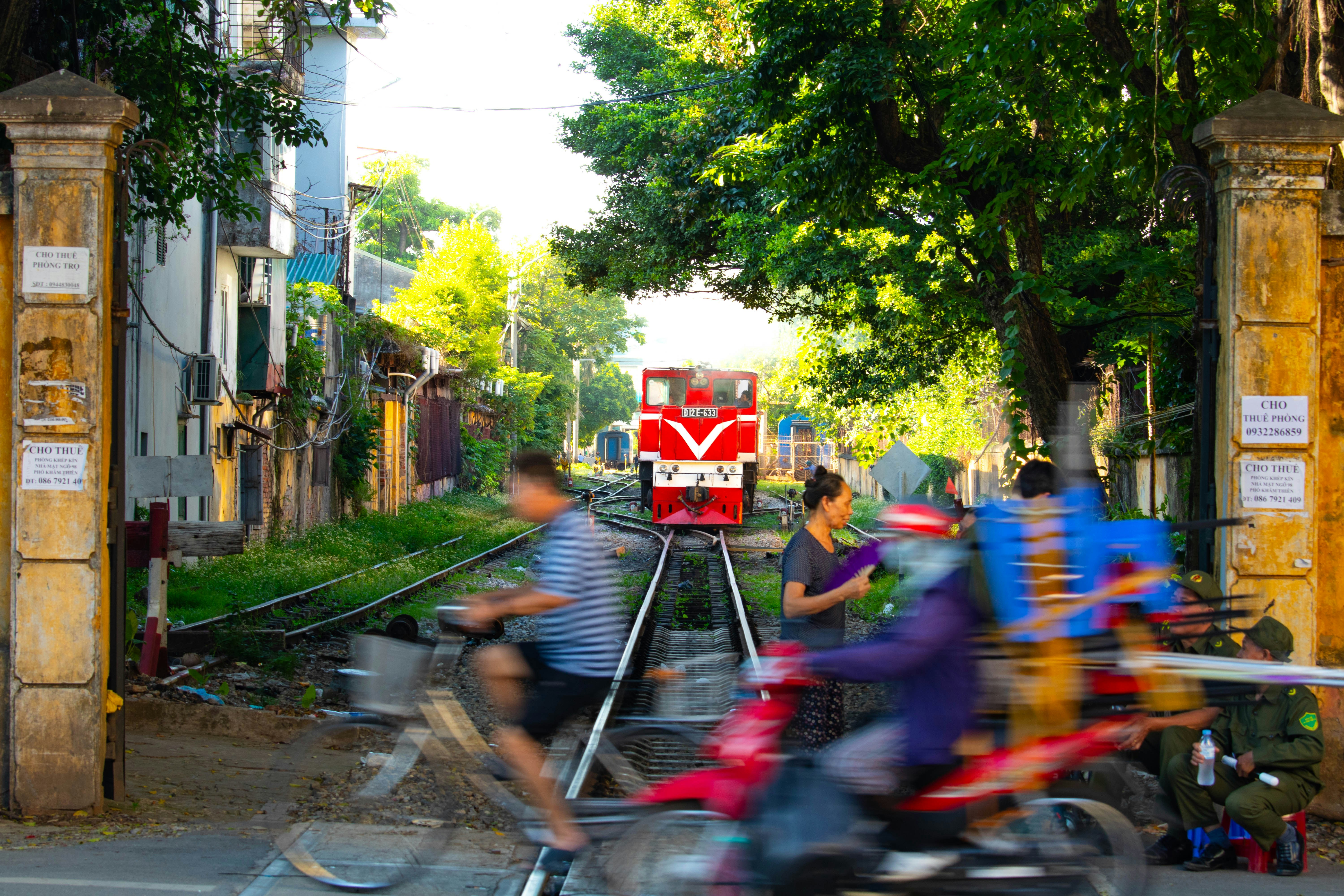 Vibrant Street Rush: A Train Backdrop Framed by Everyday Transit