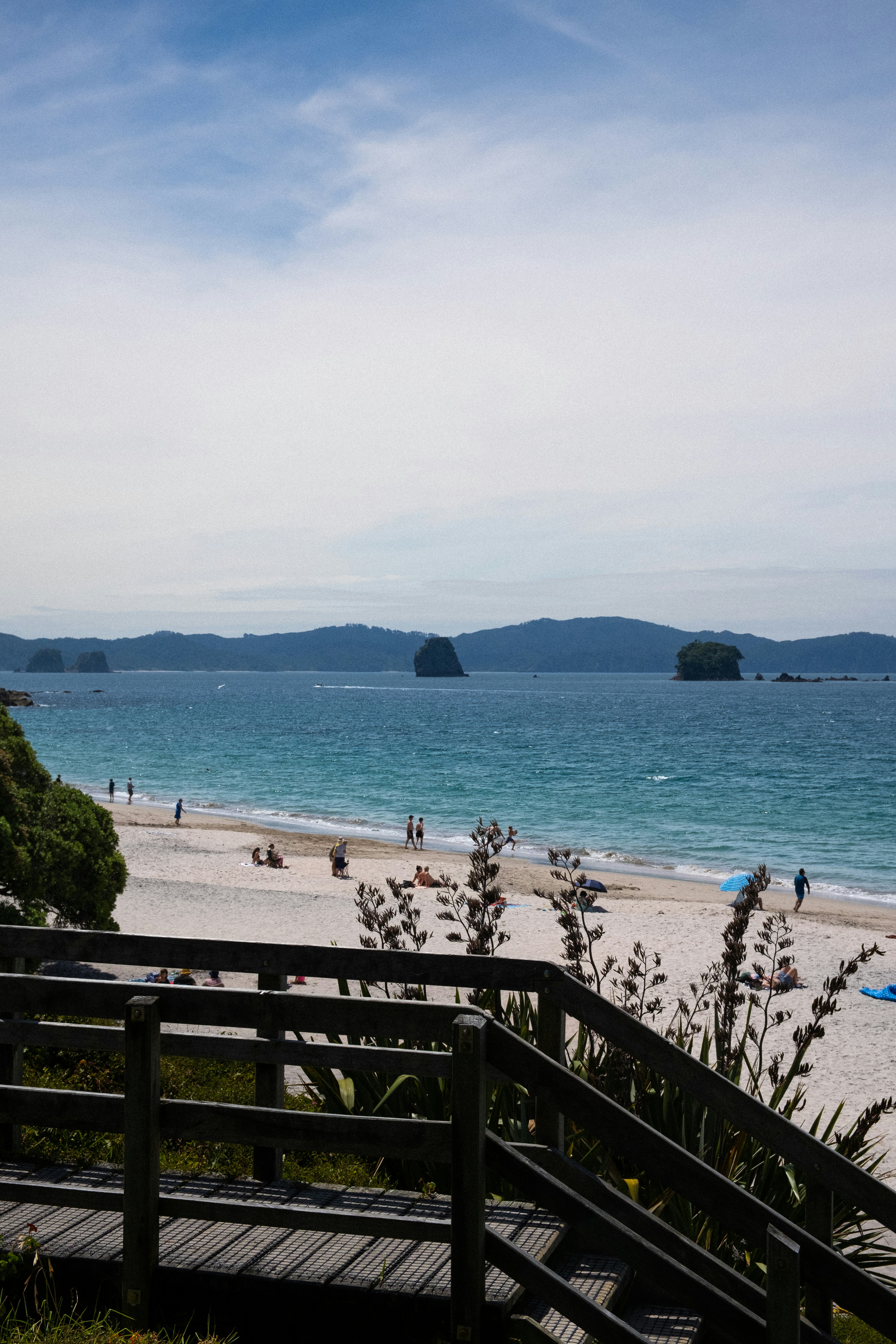 Coastal Boardwalk Framing: Beach, Sea, and Distant Isles