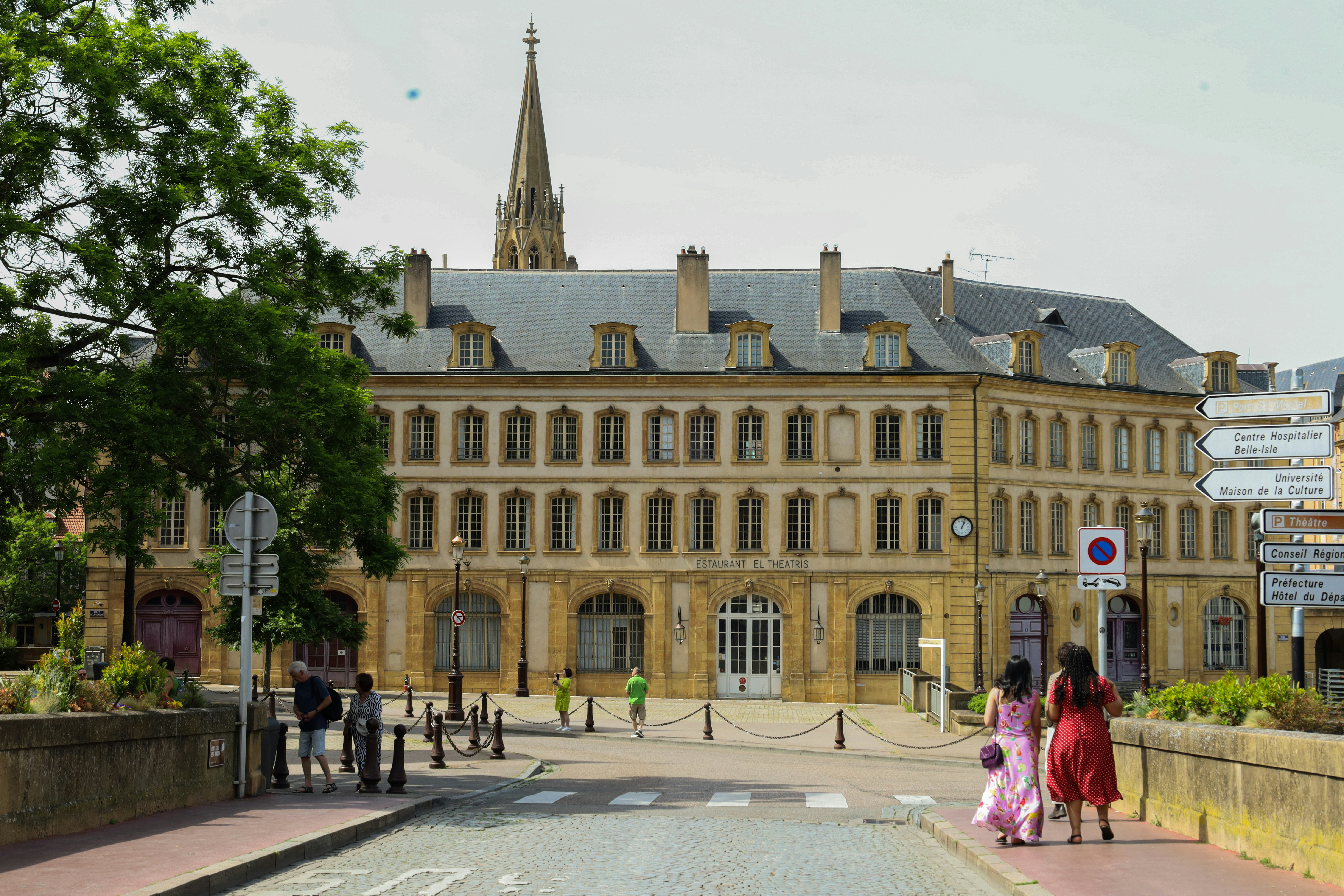 Pastel Facade Crossing: People on a Historic Bridge