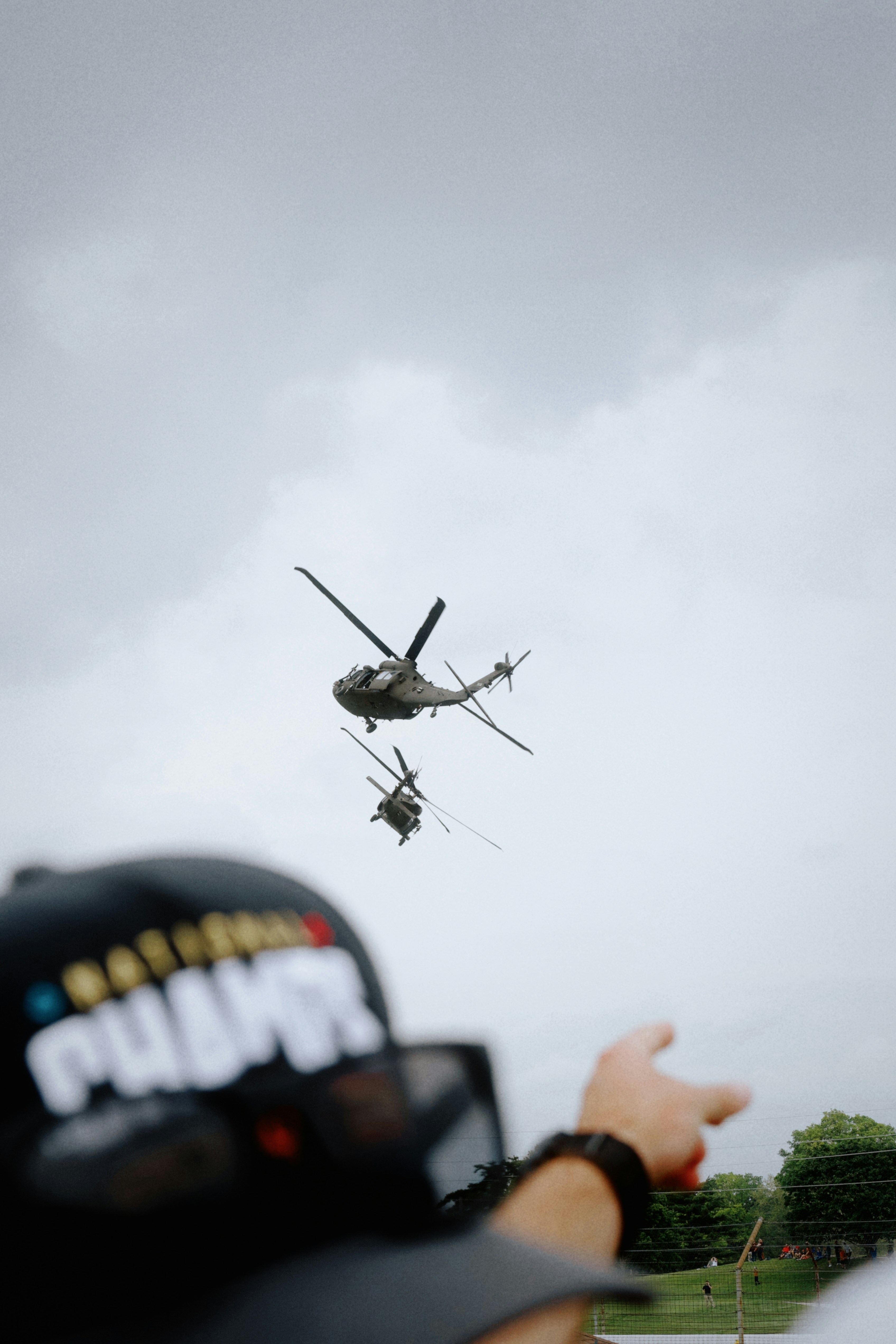 Chasing Thunder: Dual Helicopters Against a Grey Skies Backdrop