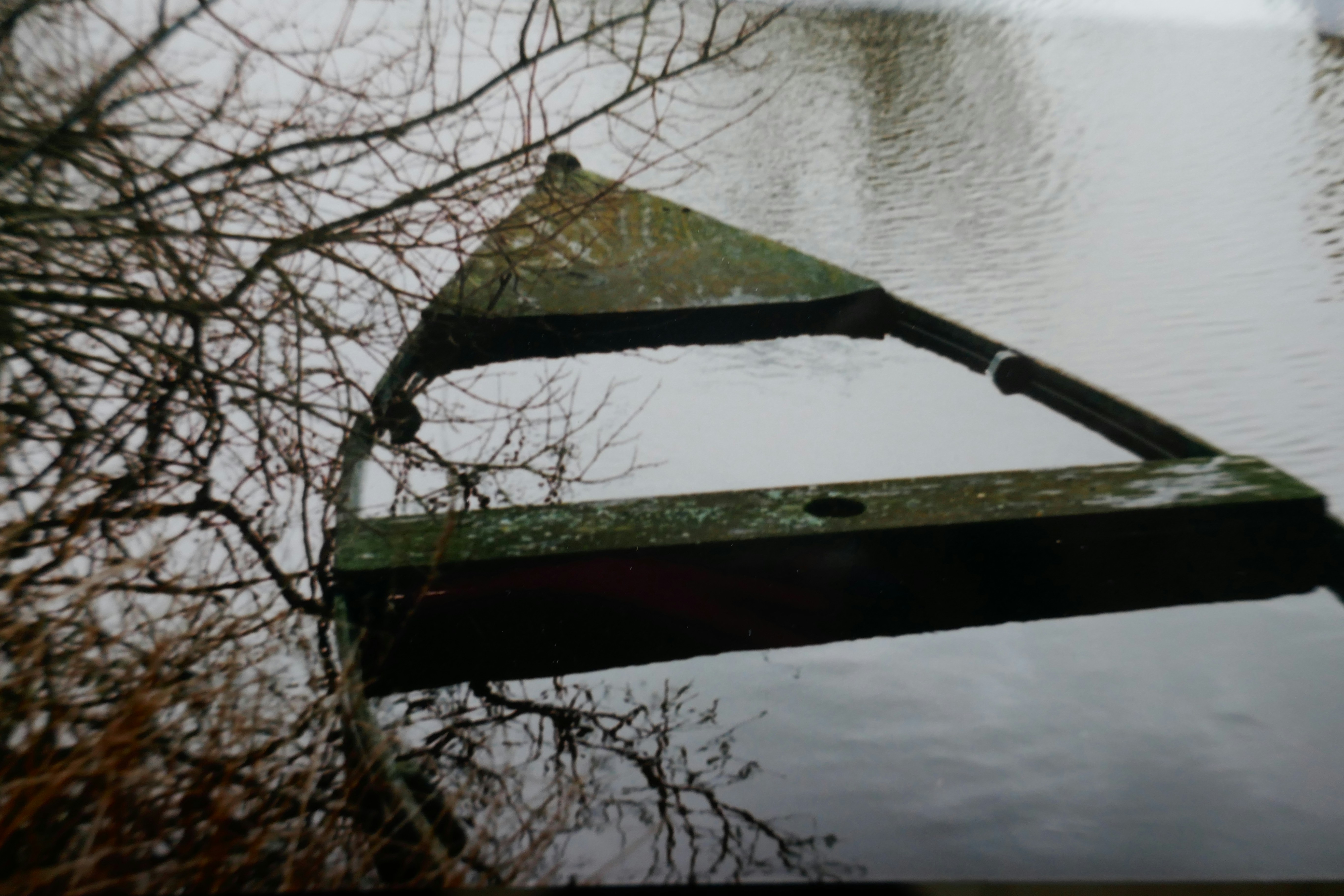 Submerged Rowboat Quietly Framed by Water and Branches