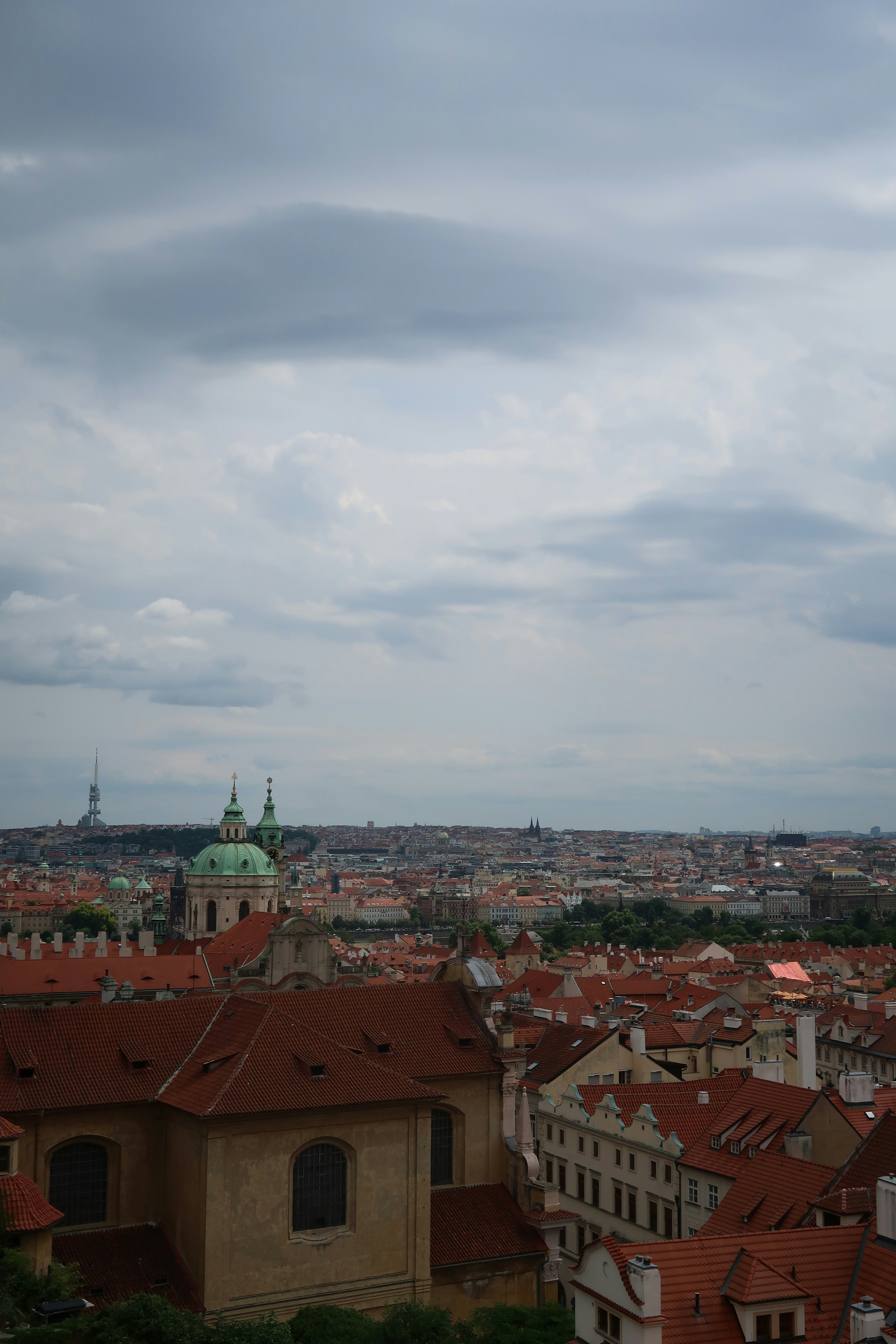 Red Tile Horizon: A Cityscape Under Clouded Sky