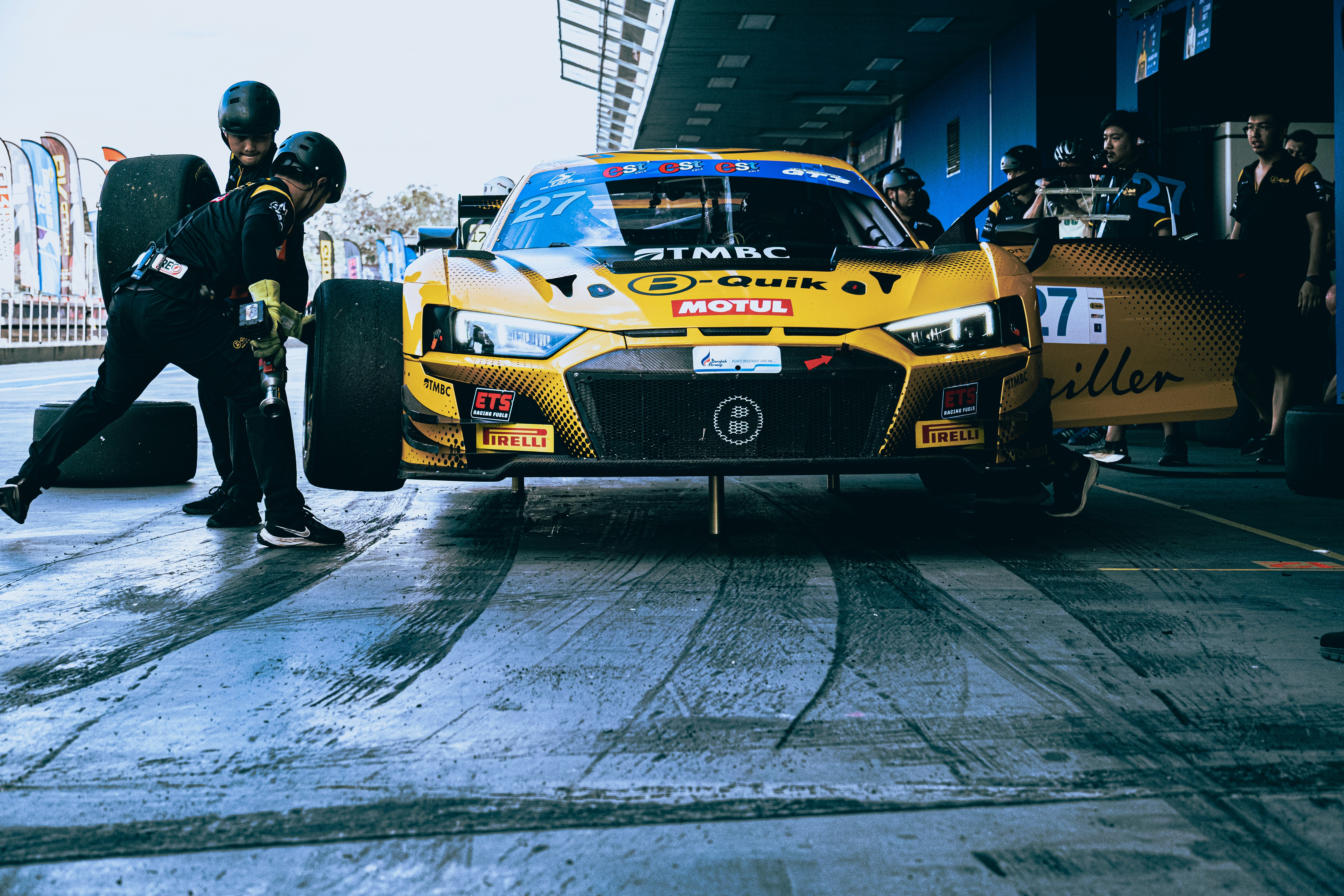 Front-Loader Sprint: Yellow GT Car in Pit Lane with Crew at Dock