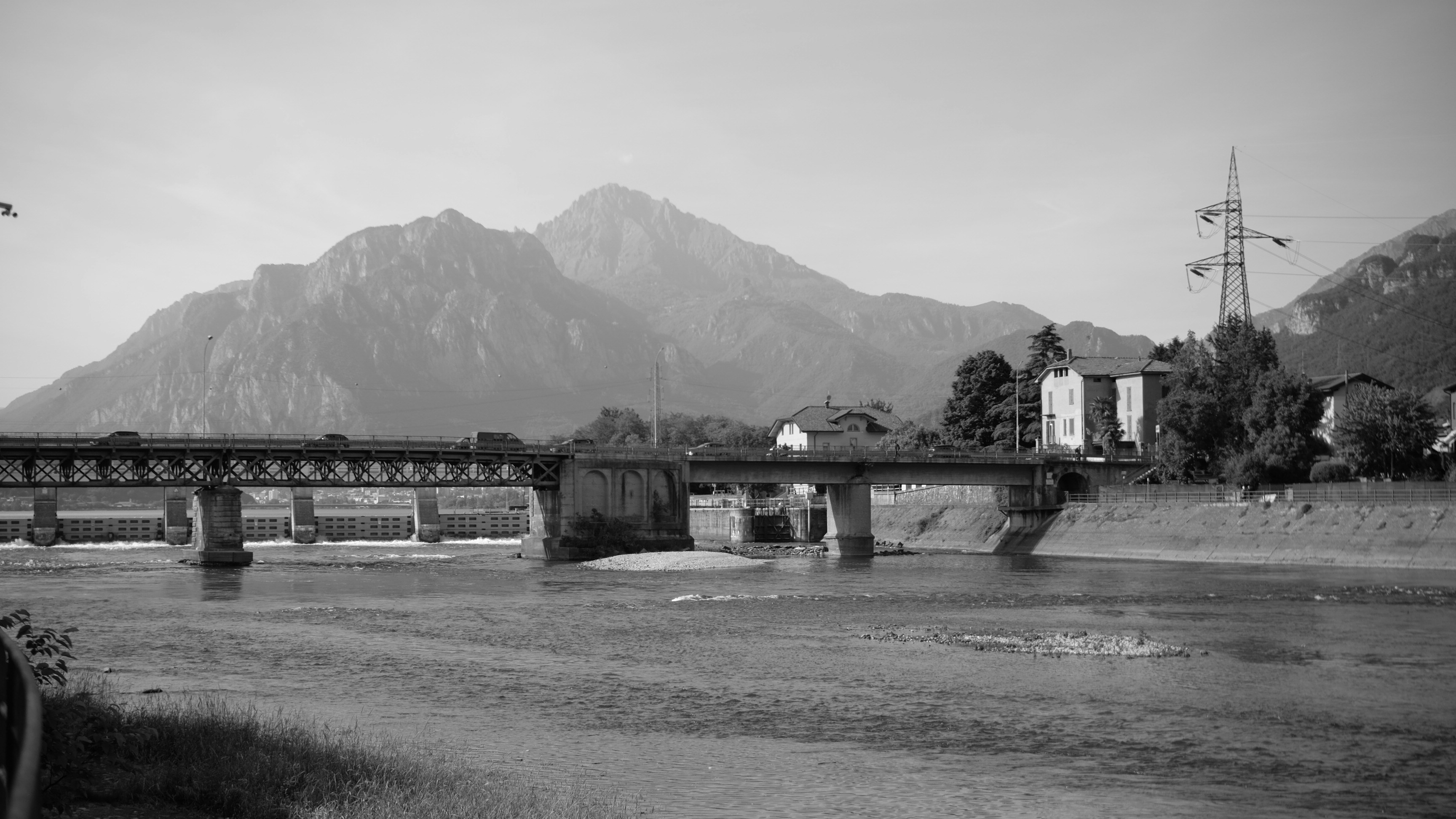 Bridge over the alpine river: quiet transit under looming peaks