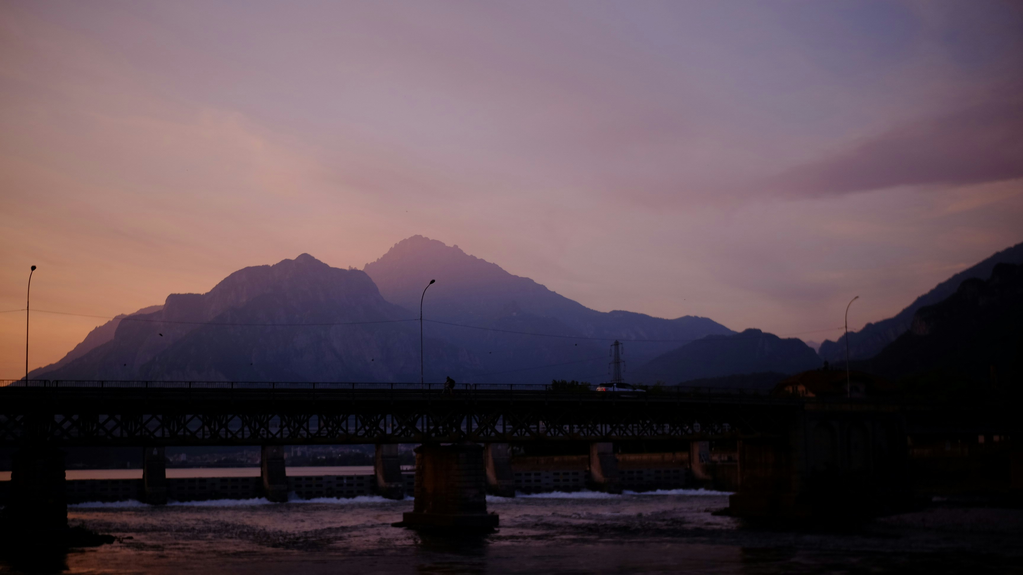 Dusk Over the River Bridge: Silhouetted Peaks and Quiet Water