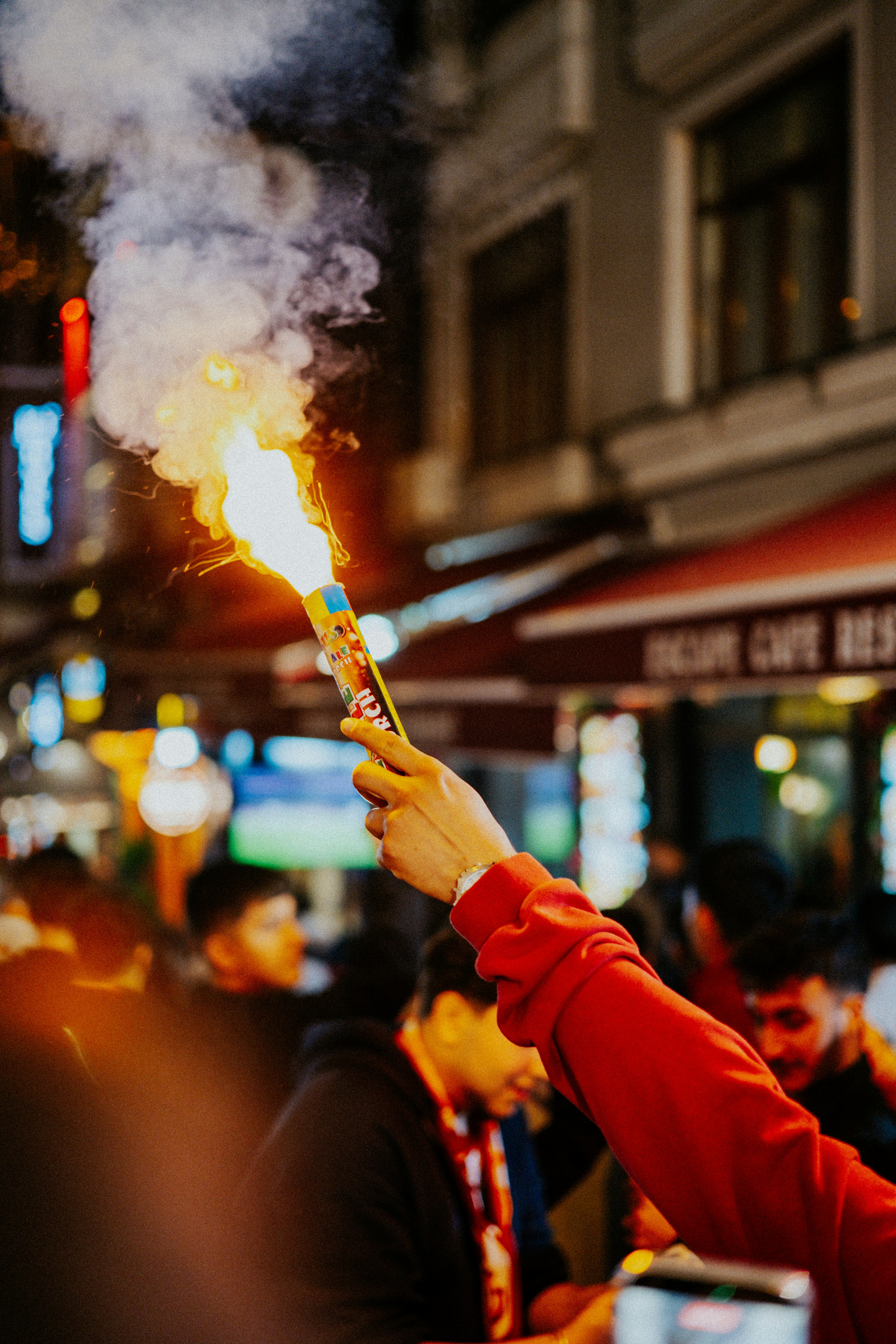 Flare of Nightlife: Handheld Pyro in a City Crowd