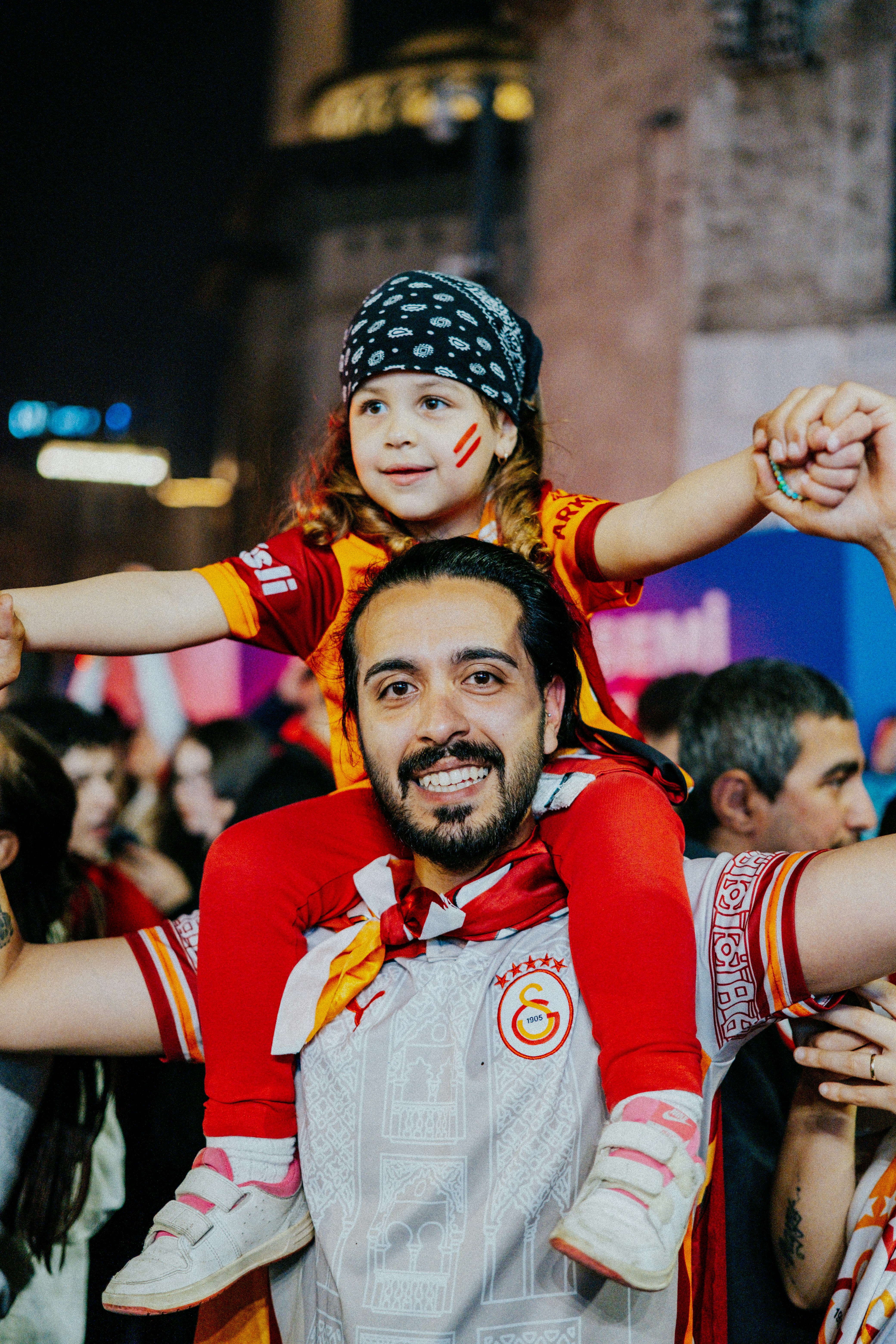 Cheerful Father with Child on Shoulders at Night Fiesta
