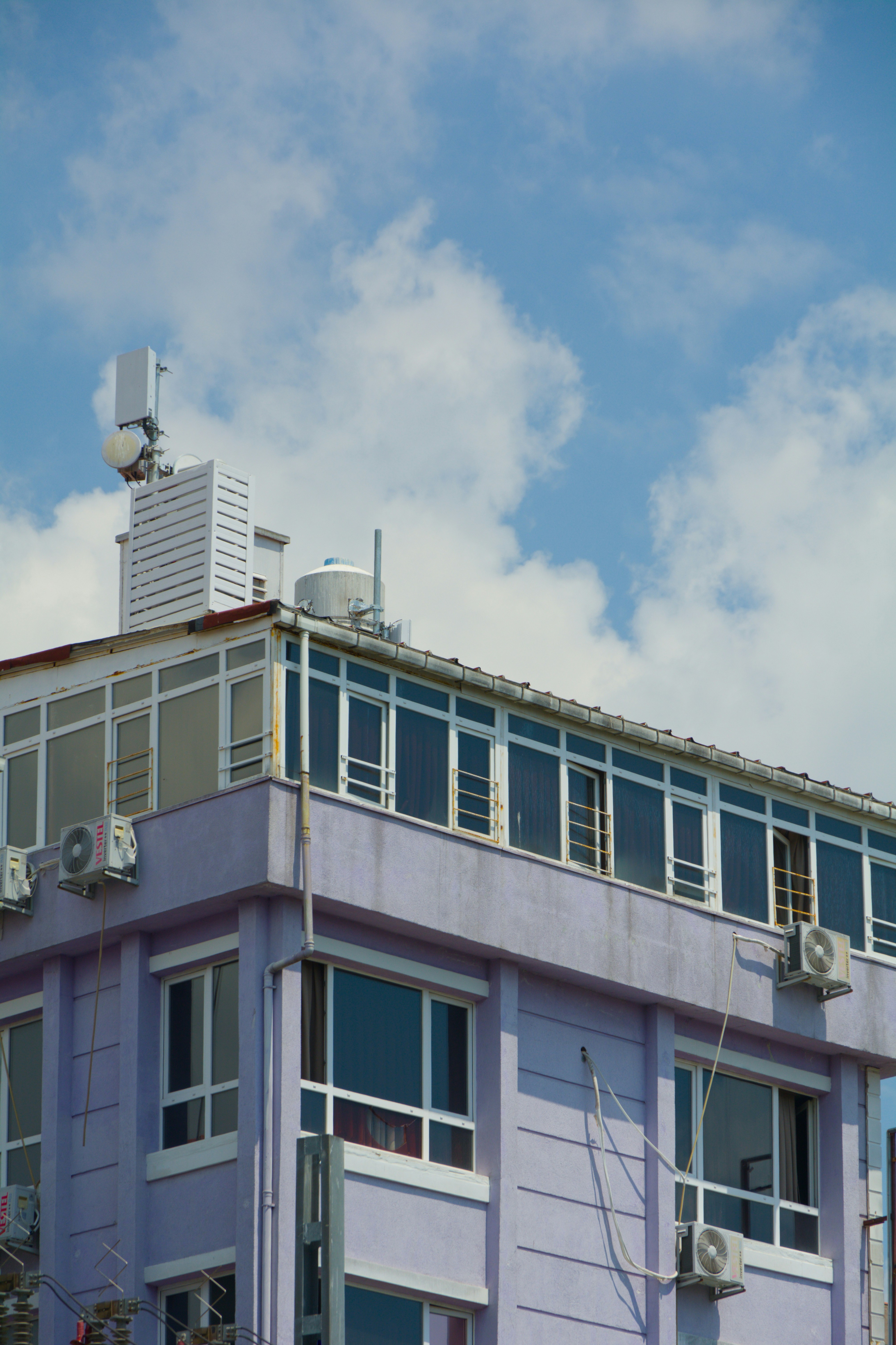 Purple-walled rooftop scene under a bright morning sky