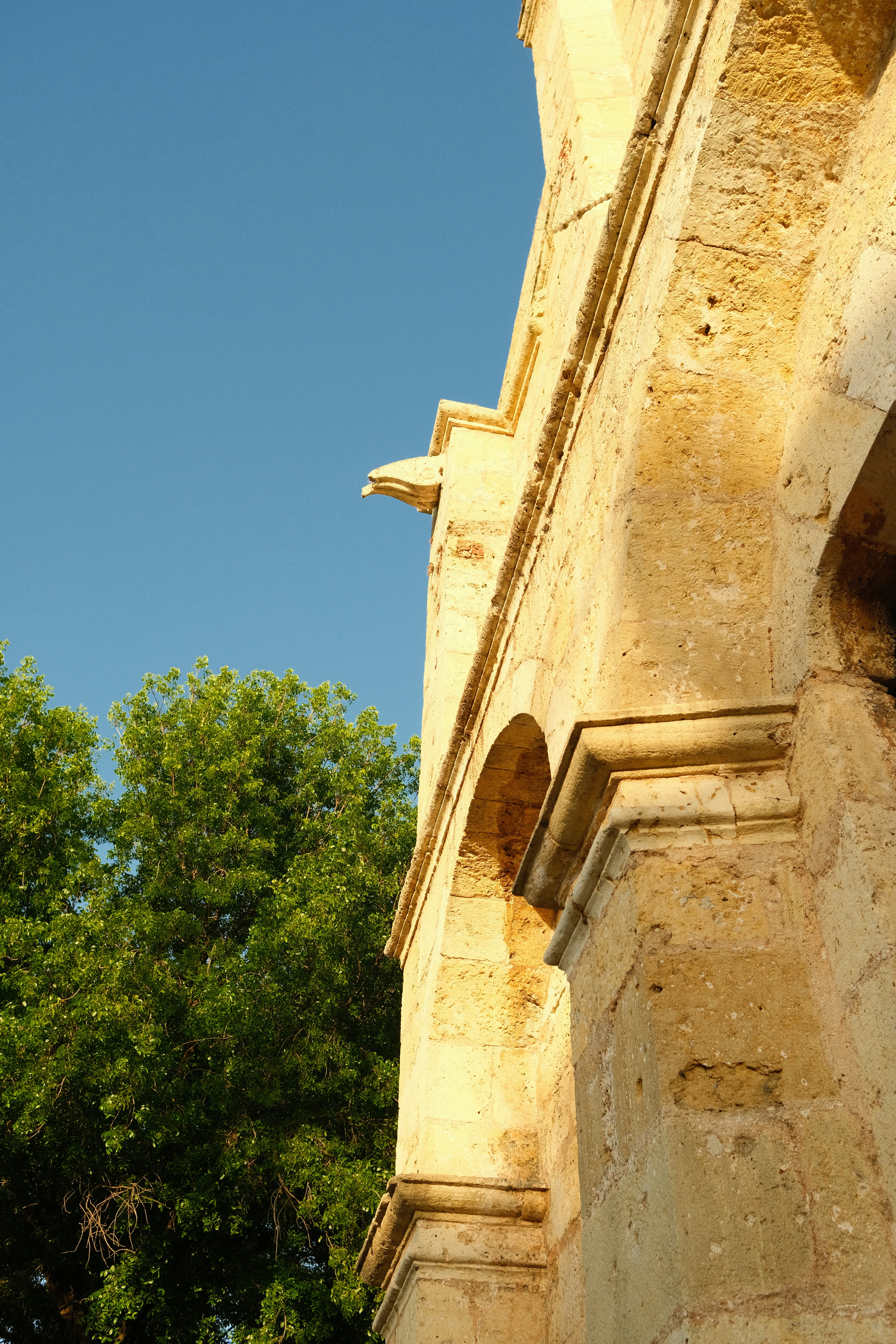 Sunlit Arc: A Corner of Ancient Stone Against Clear Sky